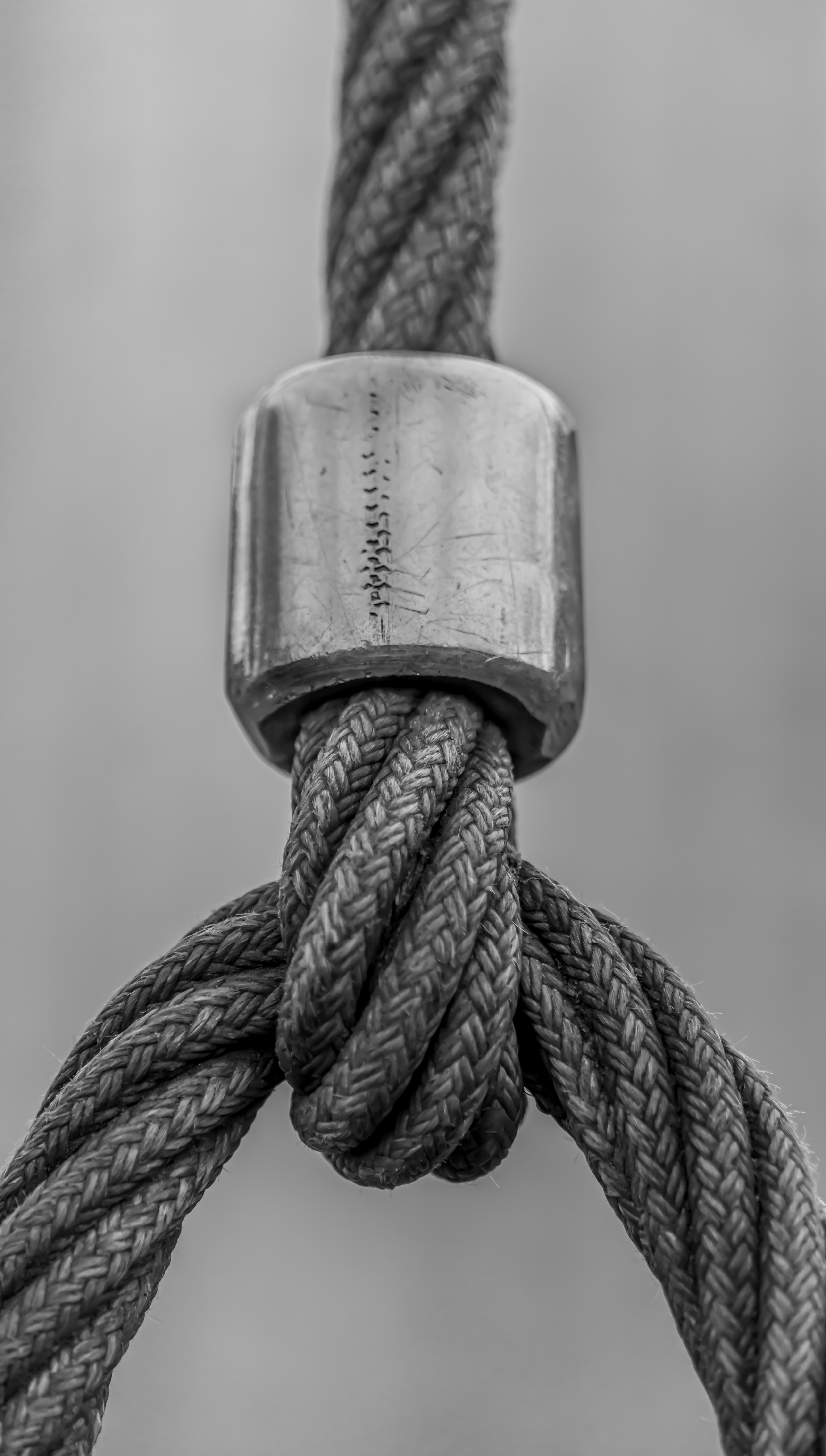 Tethered Tension: A Metallic Clamp Gripping Coarse Rope