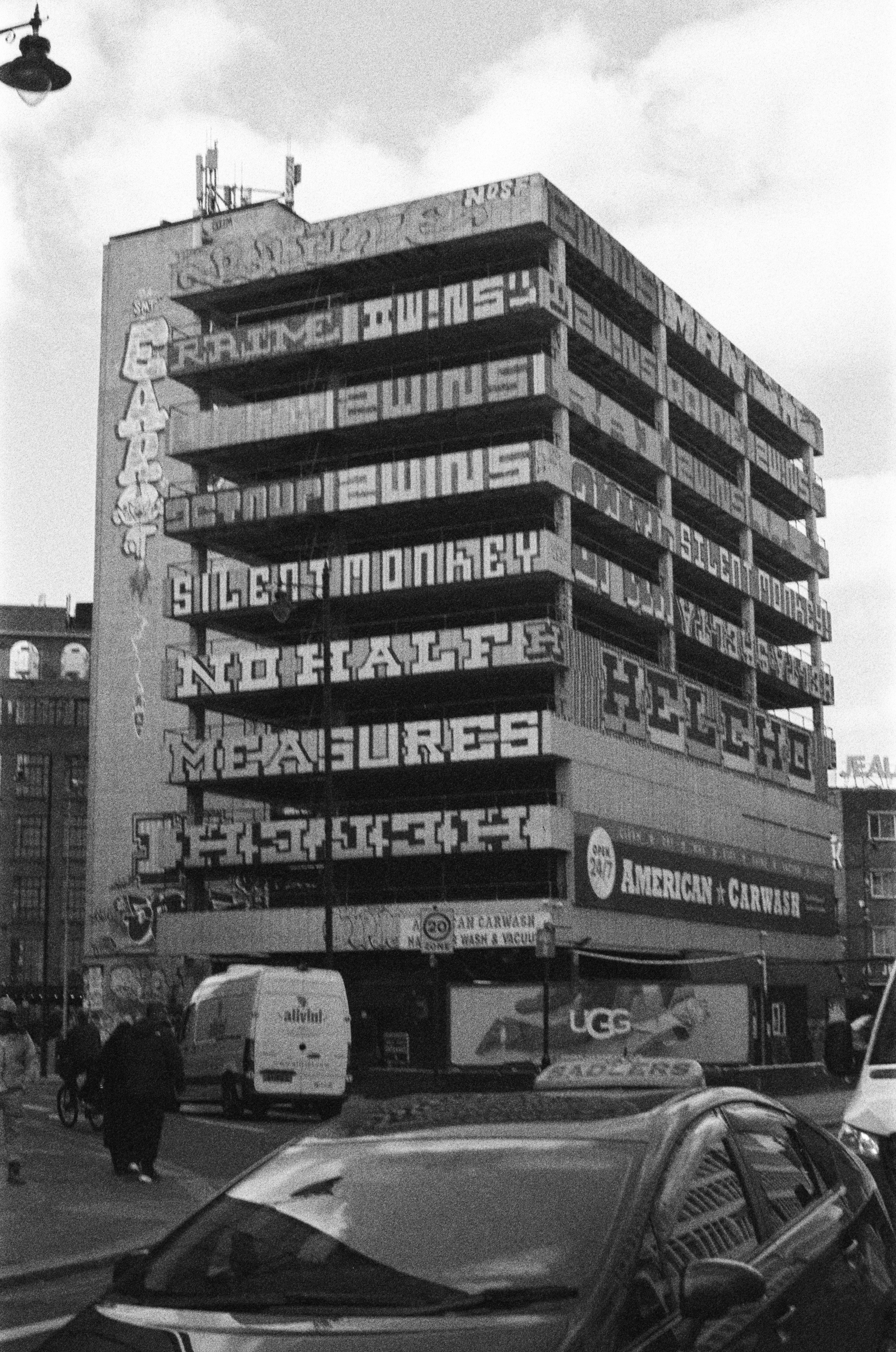 Graffiti-taped Concrete: A Multi-Story Billboarded Facade on a Busy City Street