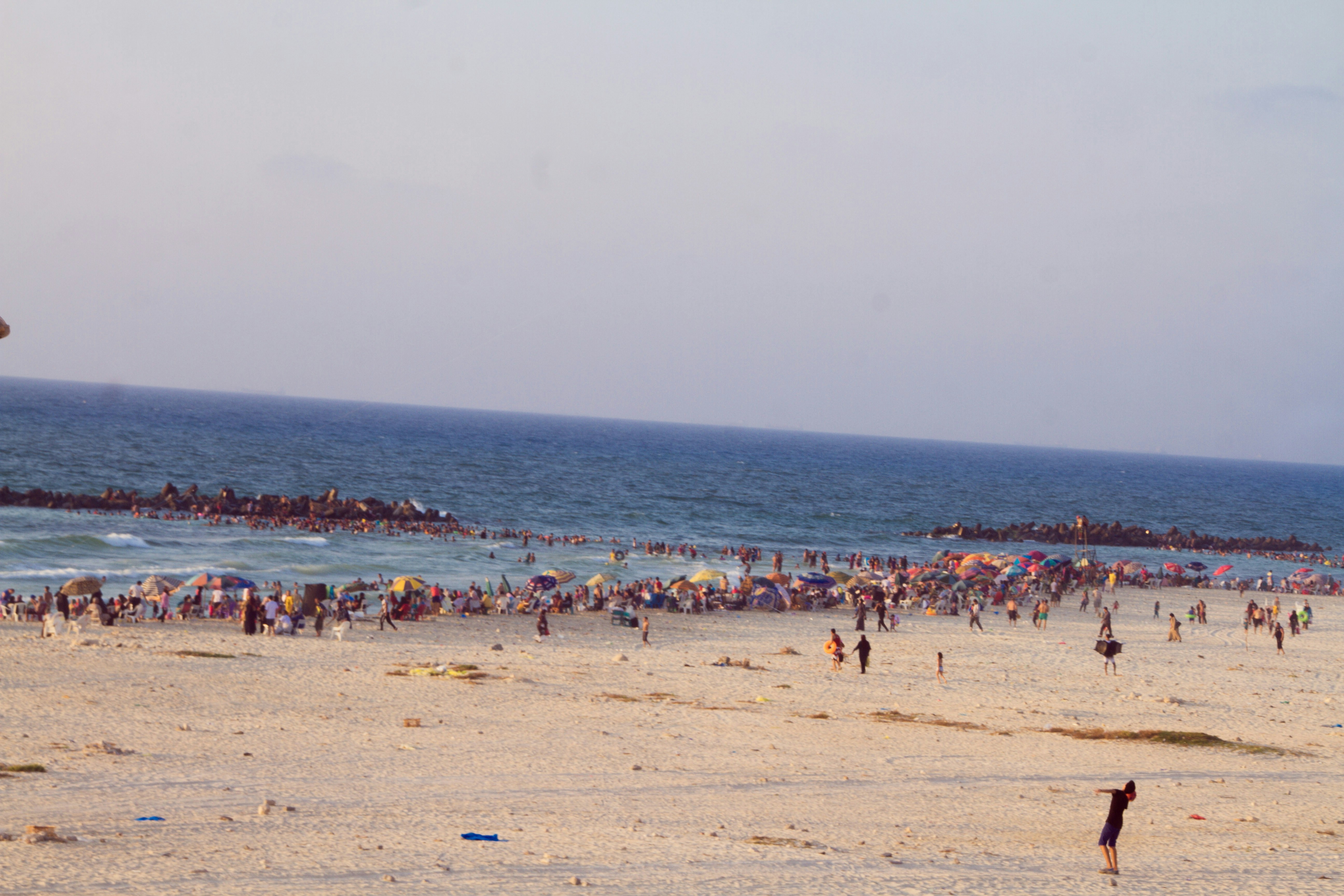 Coastline Crowd: A Sunlit Beach Scene Packed with Beachgoers