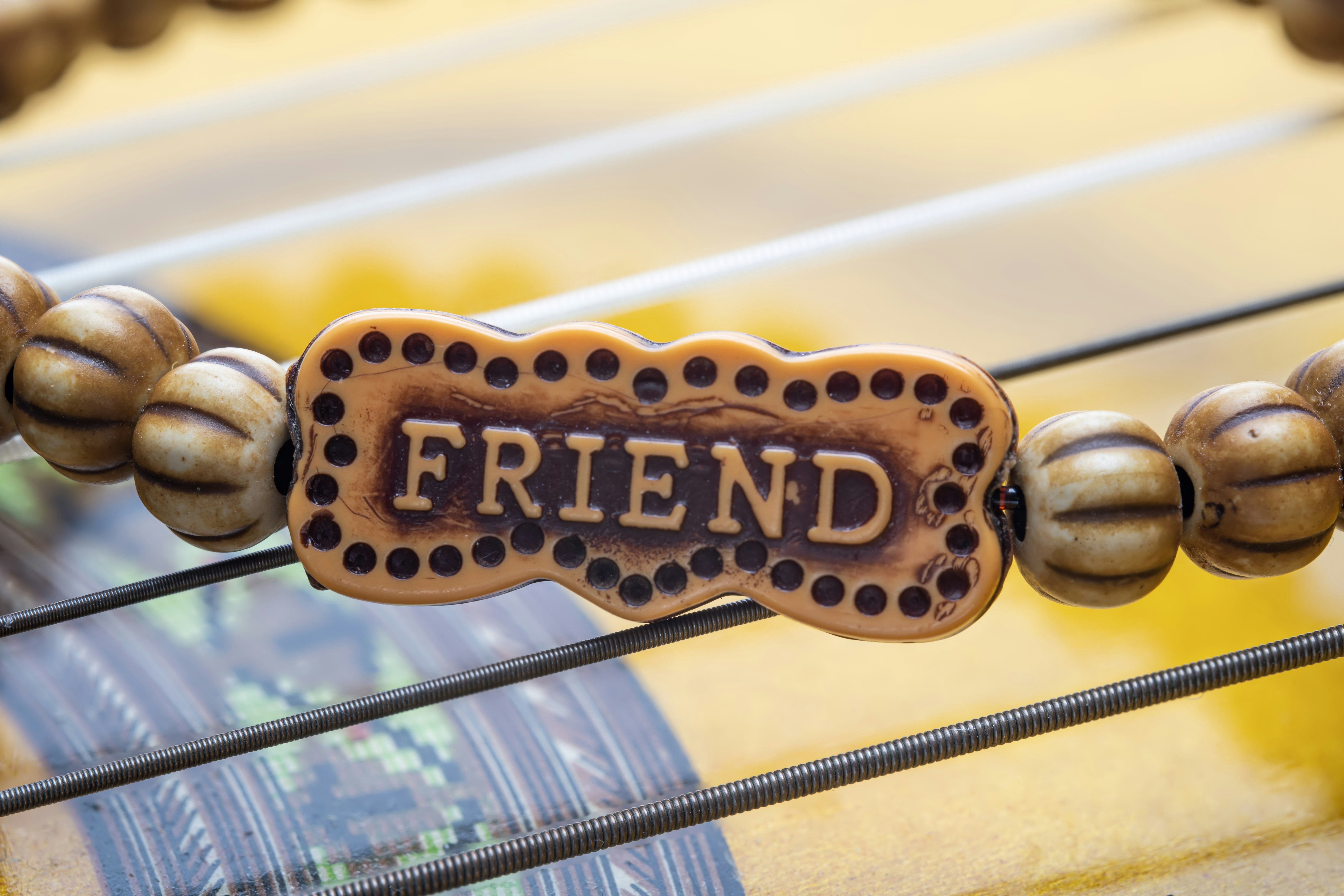 Friendship in Focus: A Leather- etched Bead Among Woven Threads