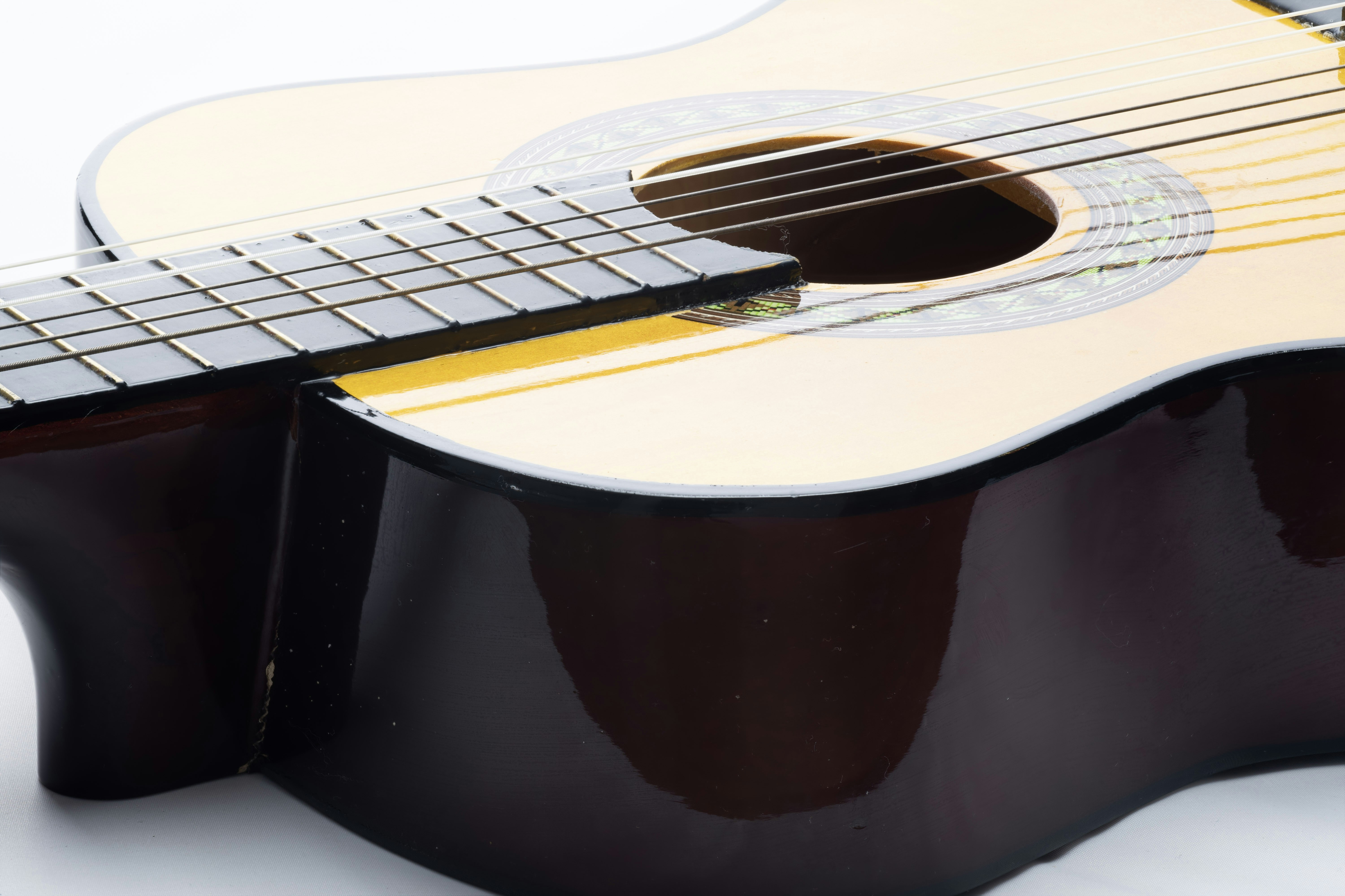 Glimmering Acoustic Gaze: Close-up of a Curved Guitar Body and Strings