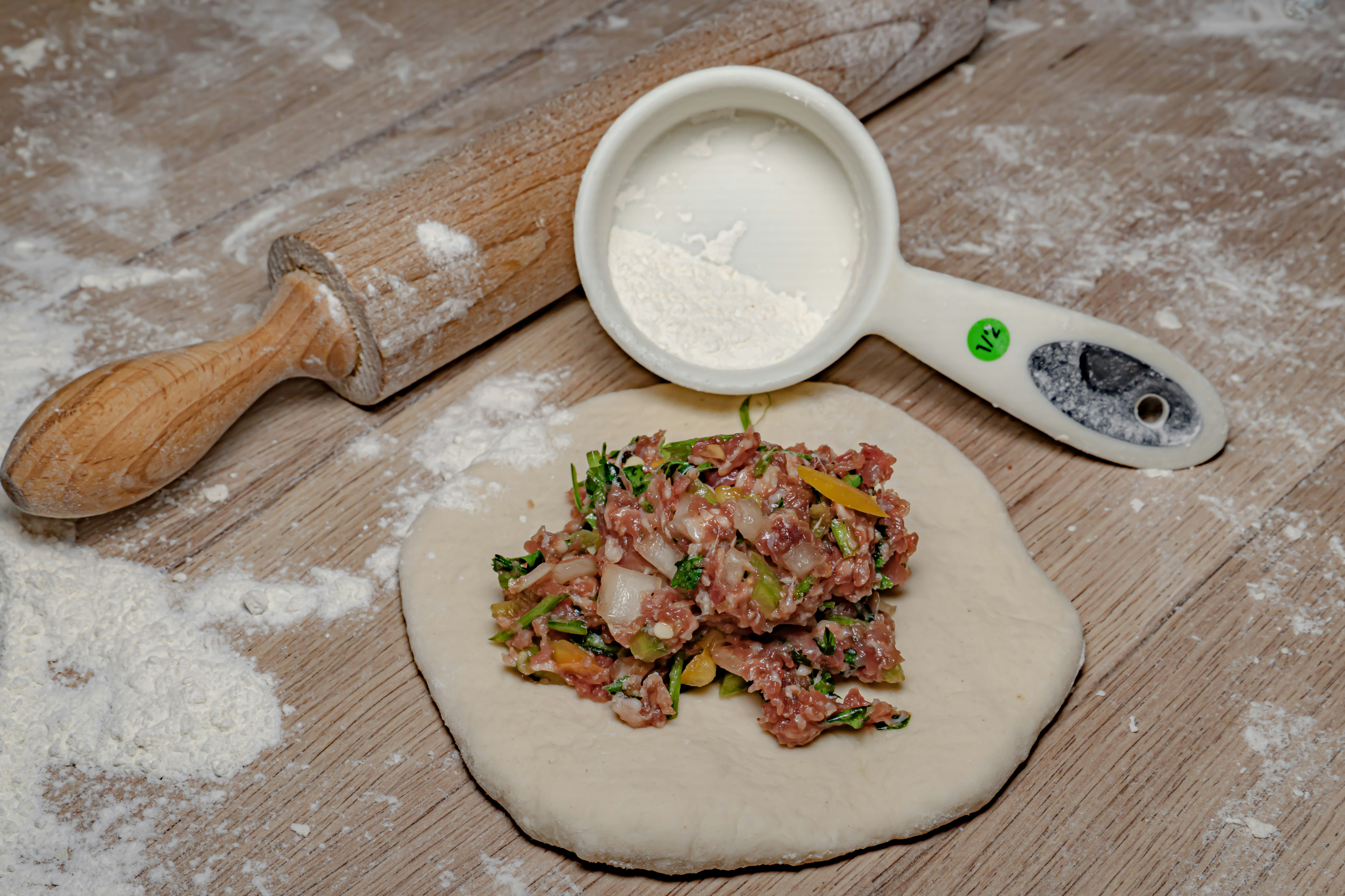 Mini Meat Fold: Unfinished Dough with Herb Filling on a Floured Work Surface
