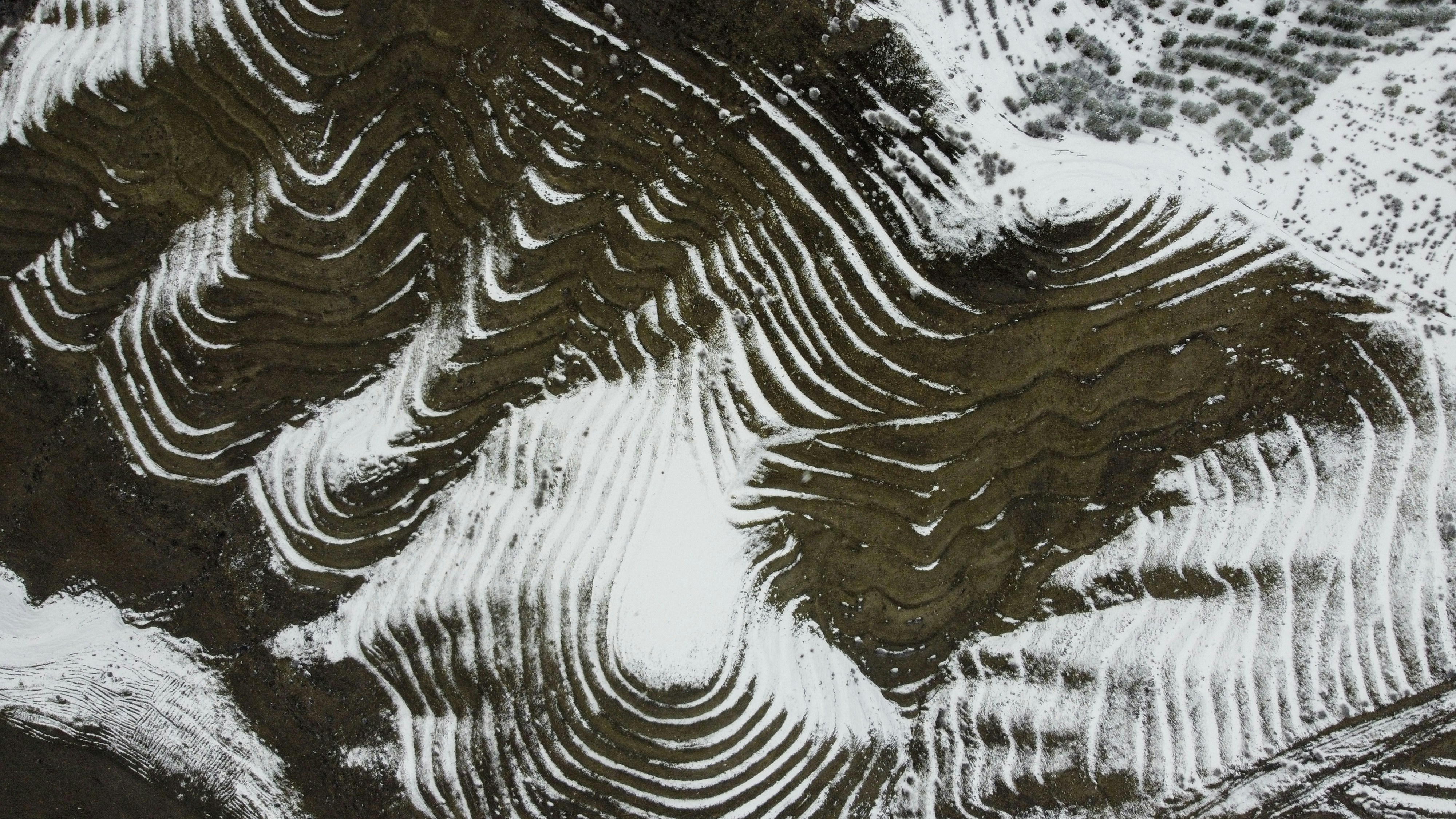 Echoes of Curved Sand: Ridge Patterns in Snow-Clecked Terrain