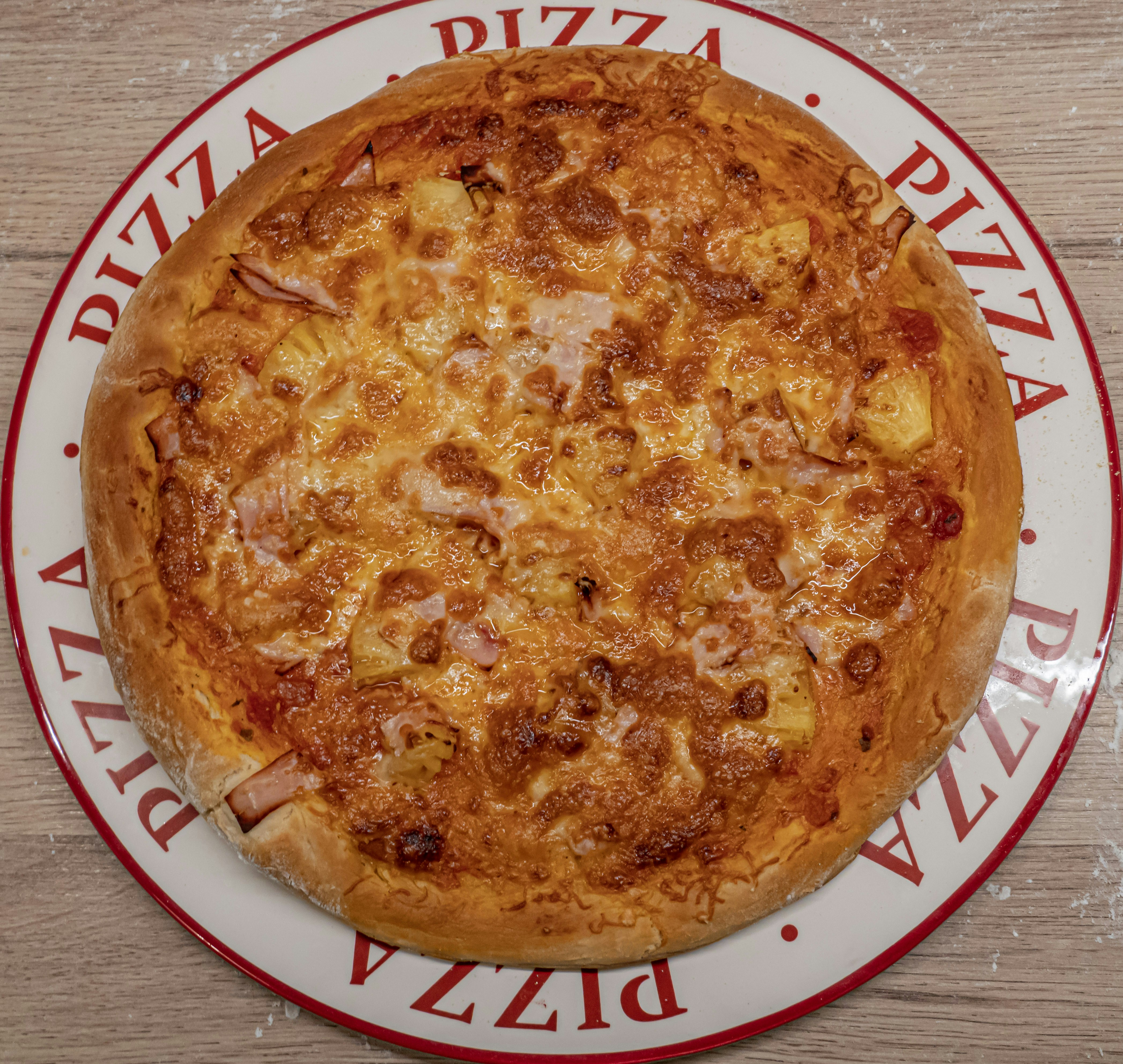 Golden Cheese Crown: A Deep-Dished Pizza on a Red-Rim Plate