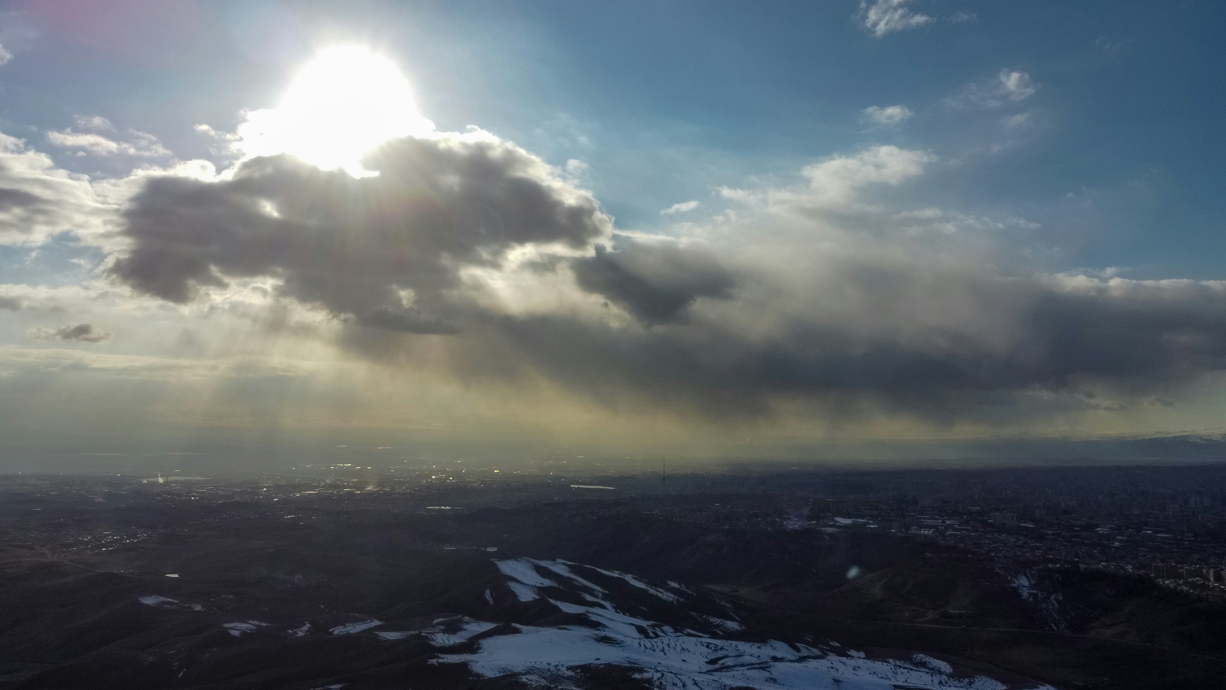 Sunlit Break in the Clouds Over Distant Terrains