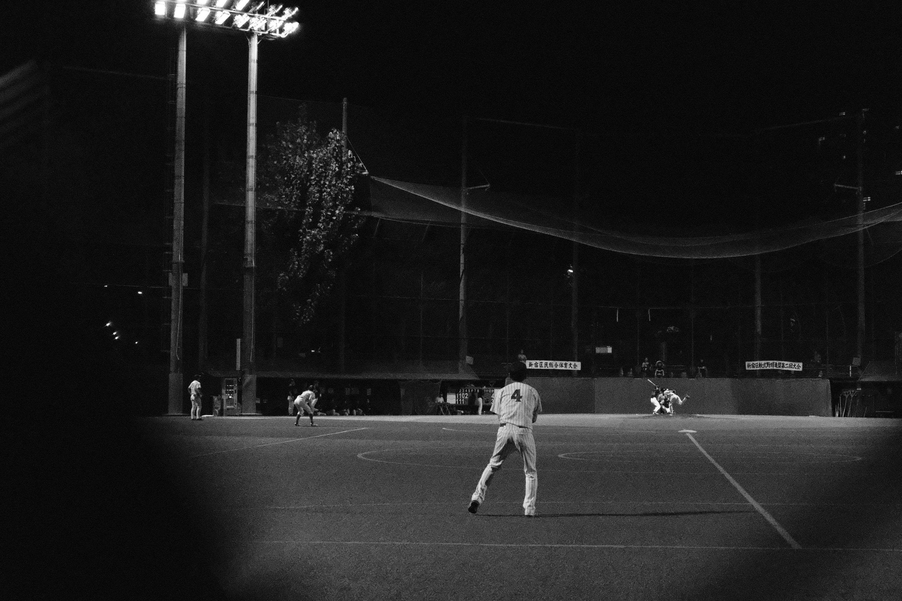 Night Game: Lone Pitcher Under Floodlit Sky
