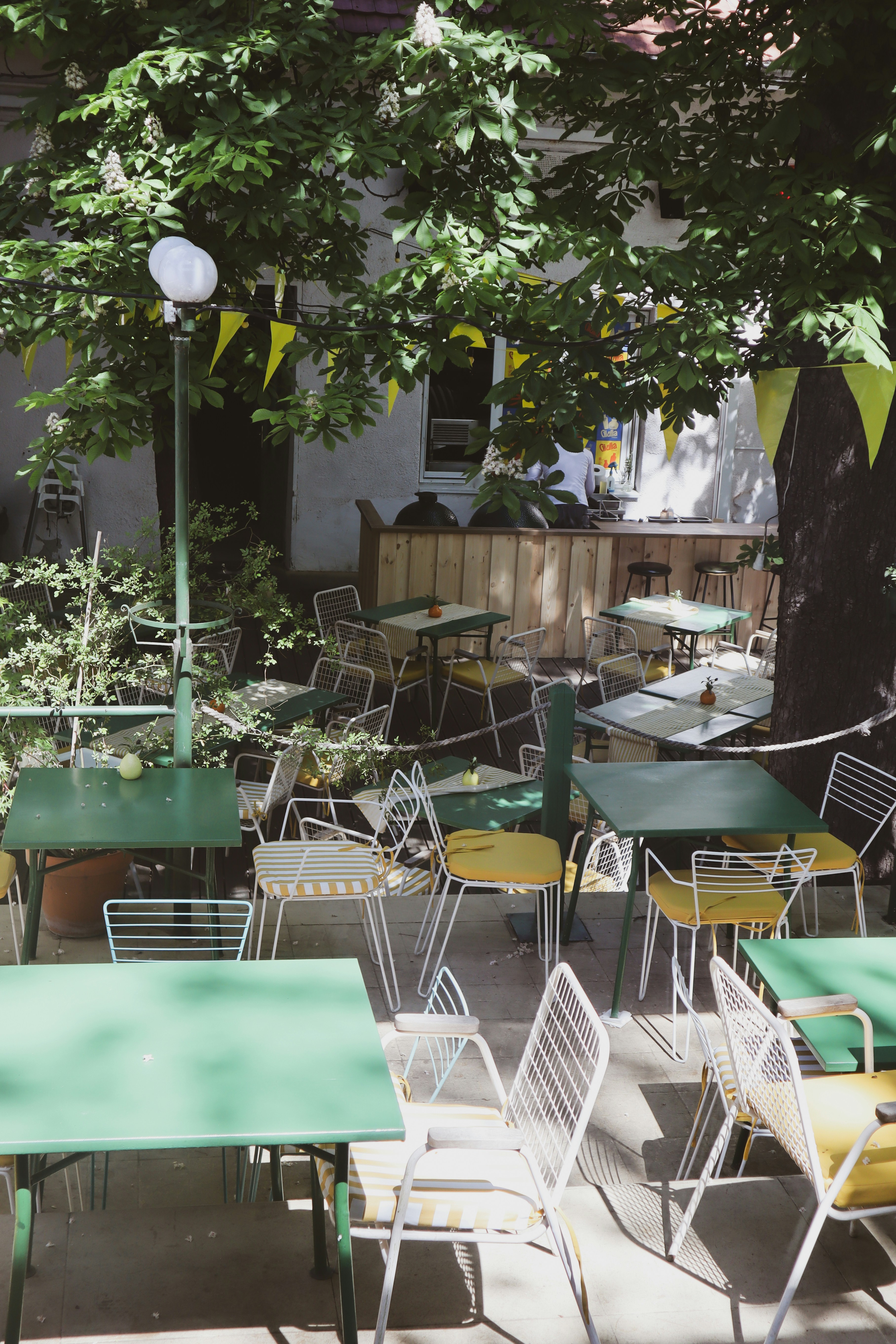 Sunlit Terrace: A Quiet Corner of Colorful Café Tables