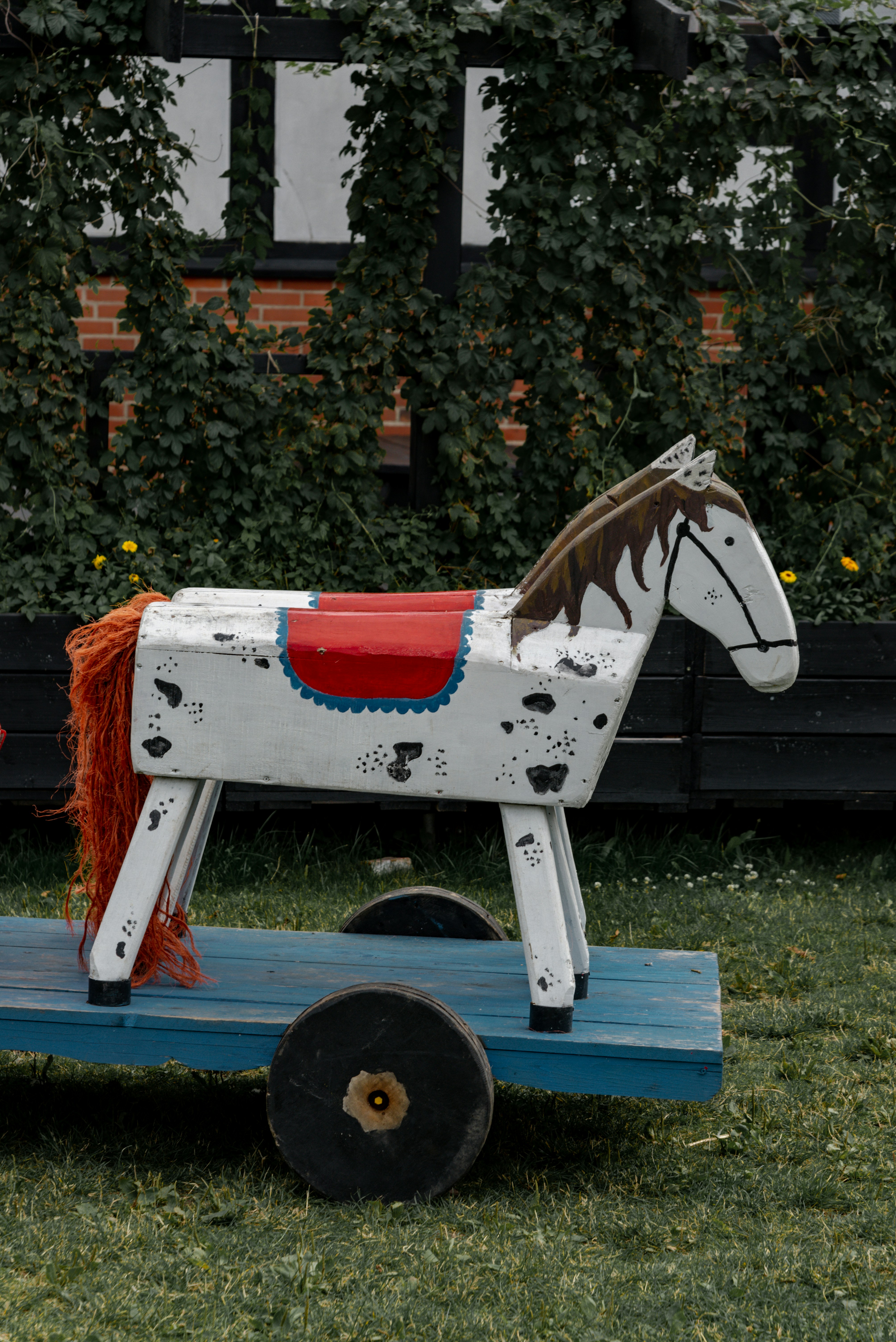 Pastime on Wheels: A Weathered Carousel Horse Rests in a Quiet Yard