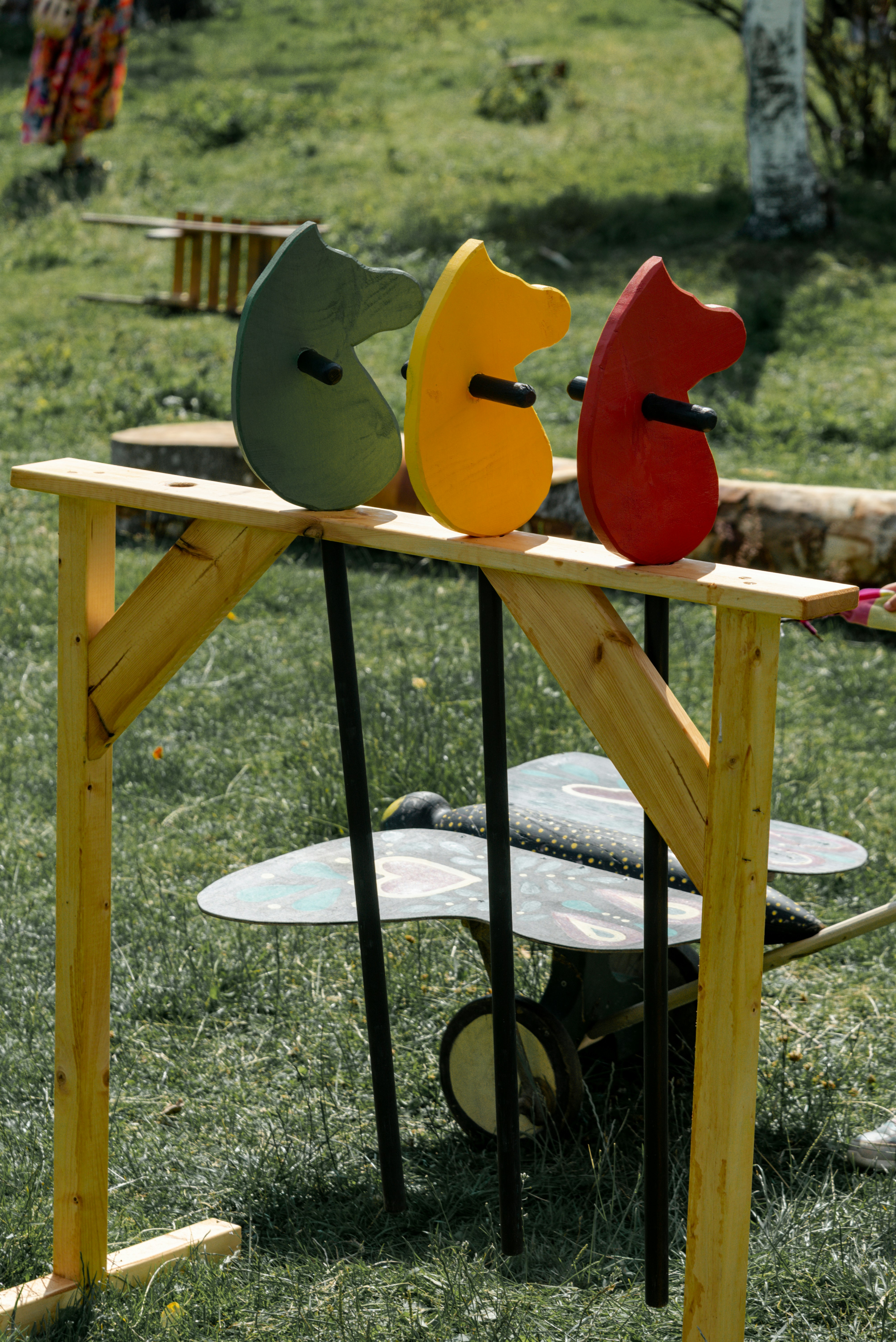 Three Painted Blades on a Timber Stage in a Sunlit Park