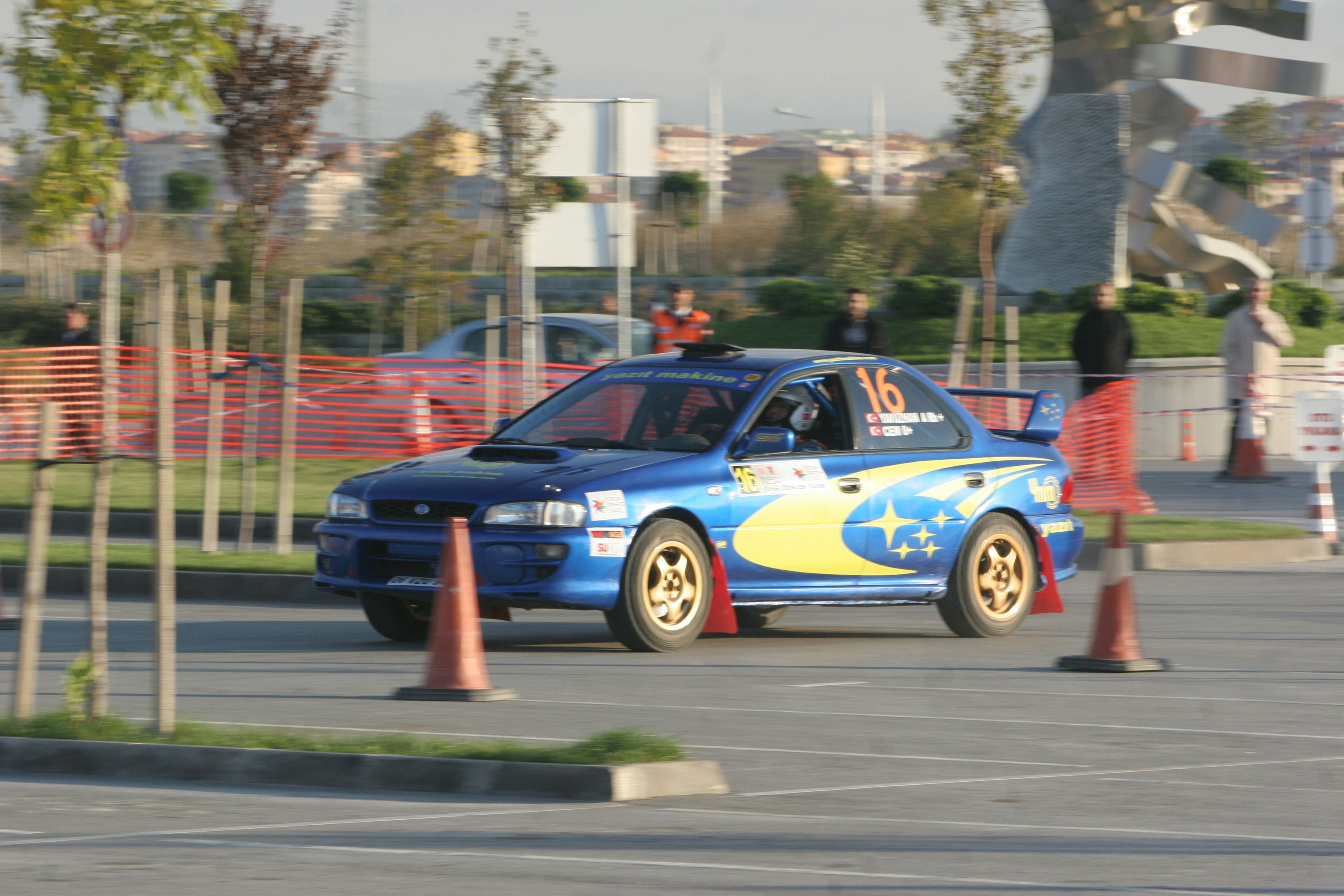 Blue rally car carving through cones in a test course