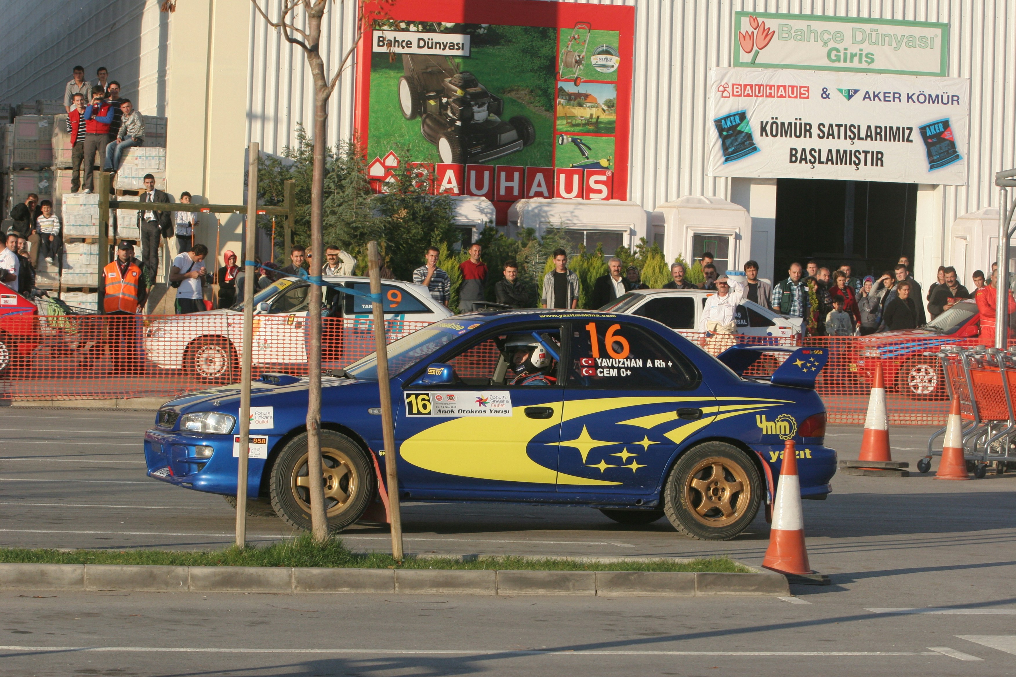 Blue Rally Car Slings Through a Street Course as Spectators Watch