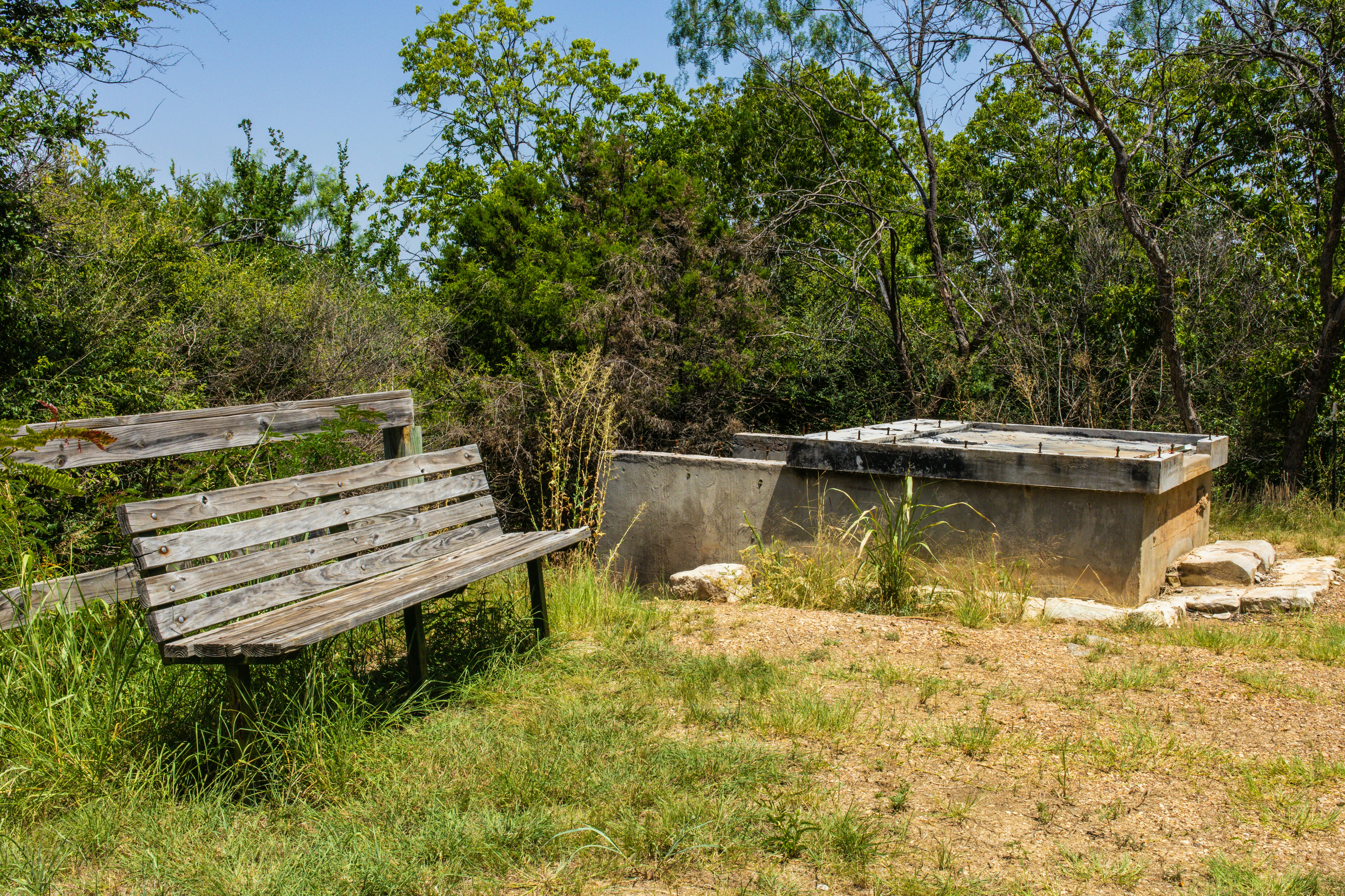 Weathered benches beside a sunlit, rocky overlook