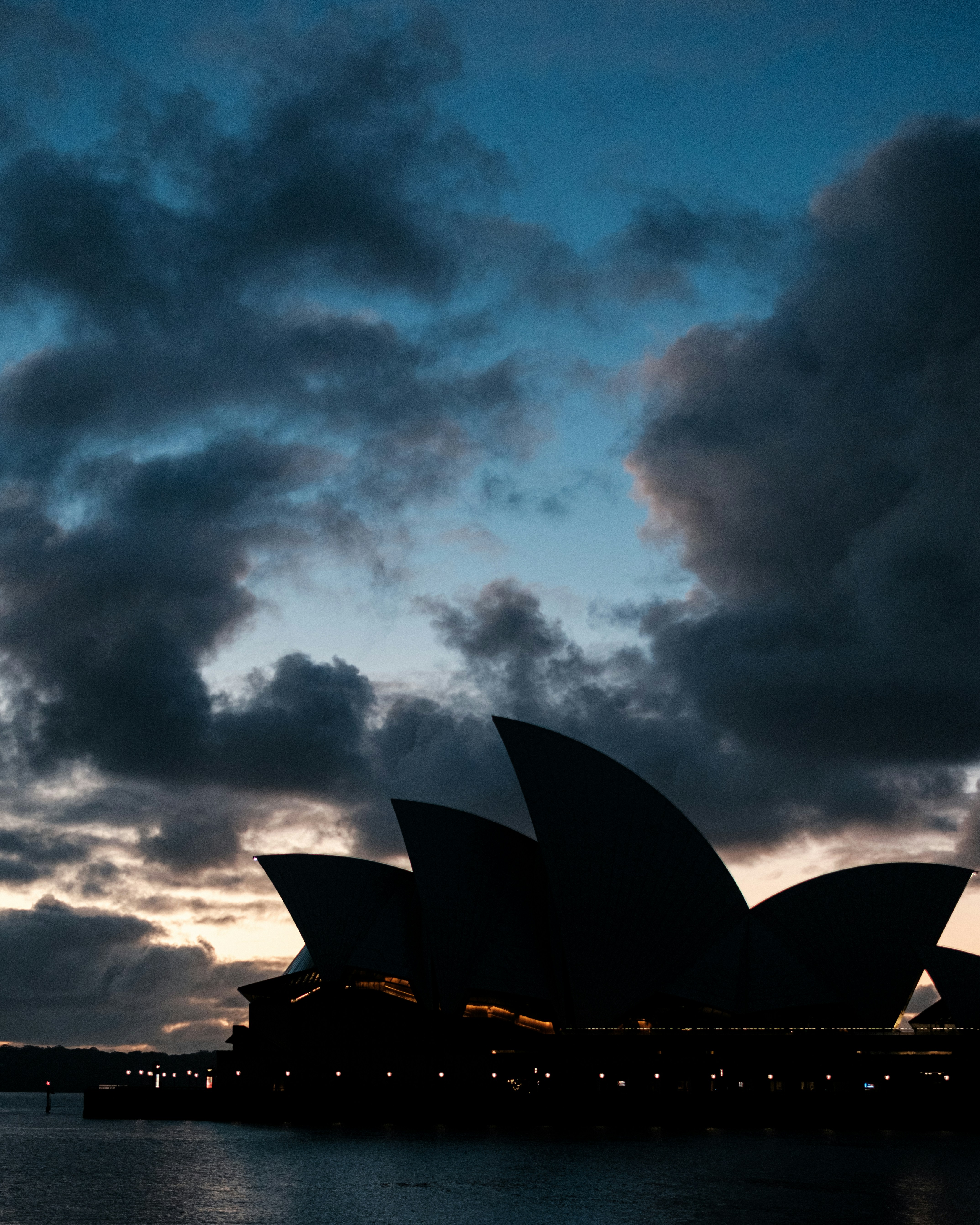 Silhouette at Dusk: The Opera House Beneath Tidal Clouds