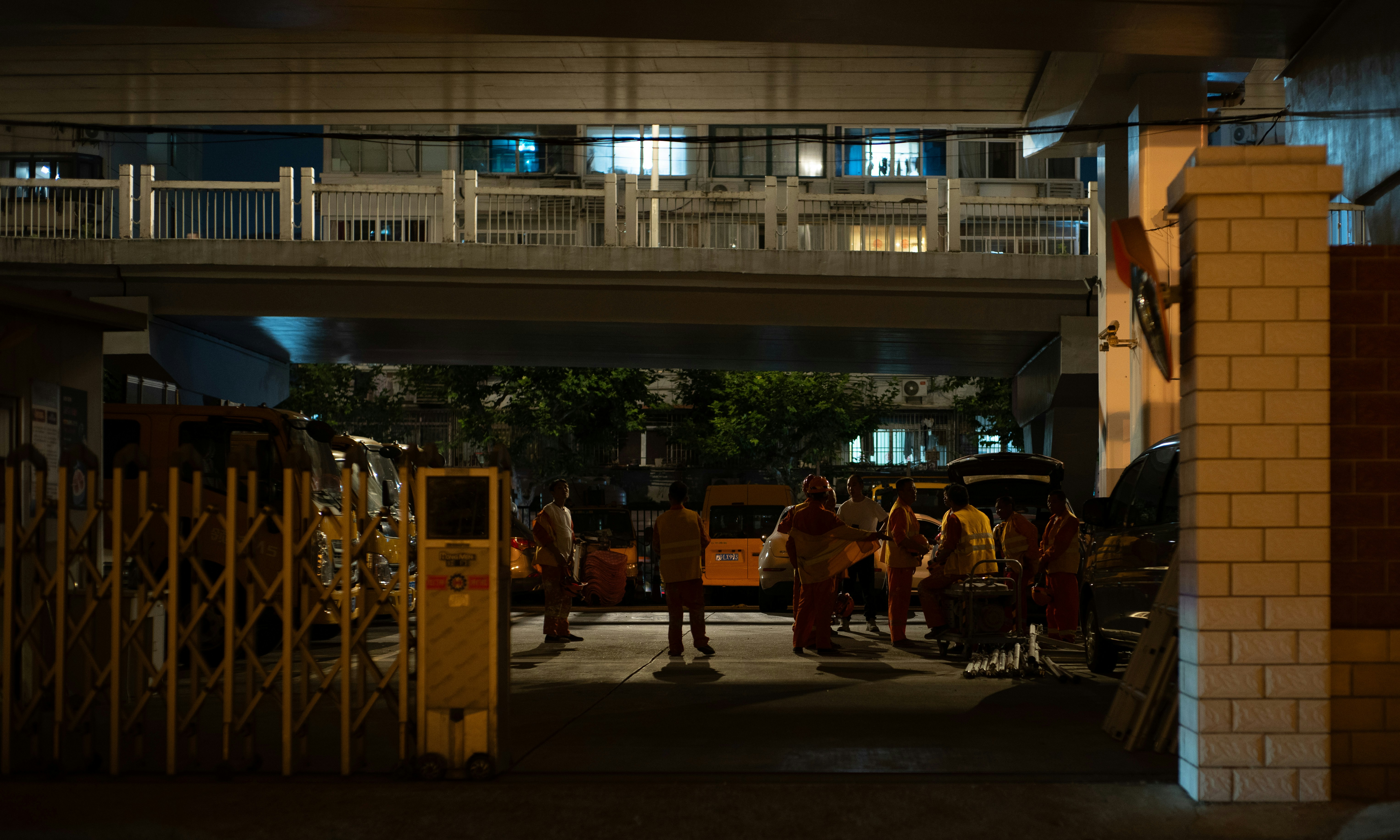 Night Crew Under the Overpass: A Dimly Lit Urban Window