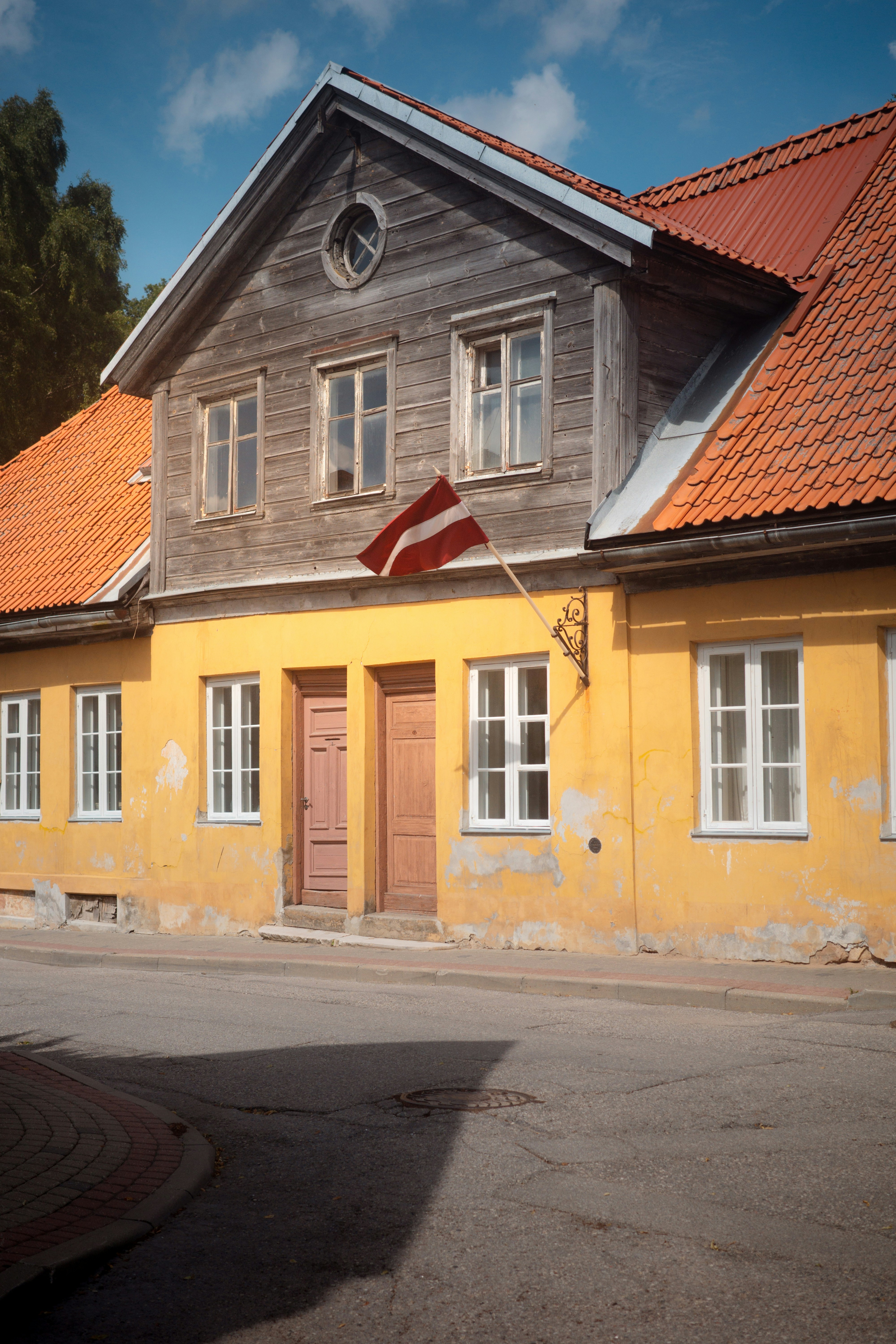 Sunlit Yellow Facade with a Flag-Flaunting Gable
