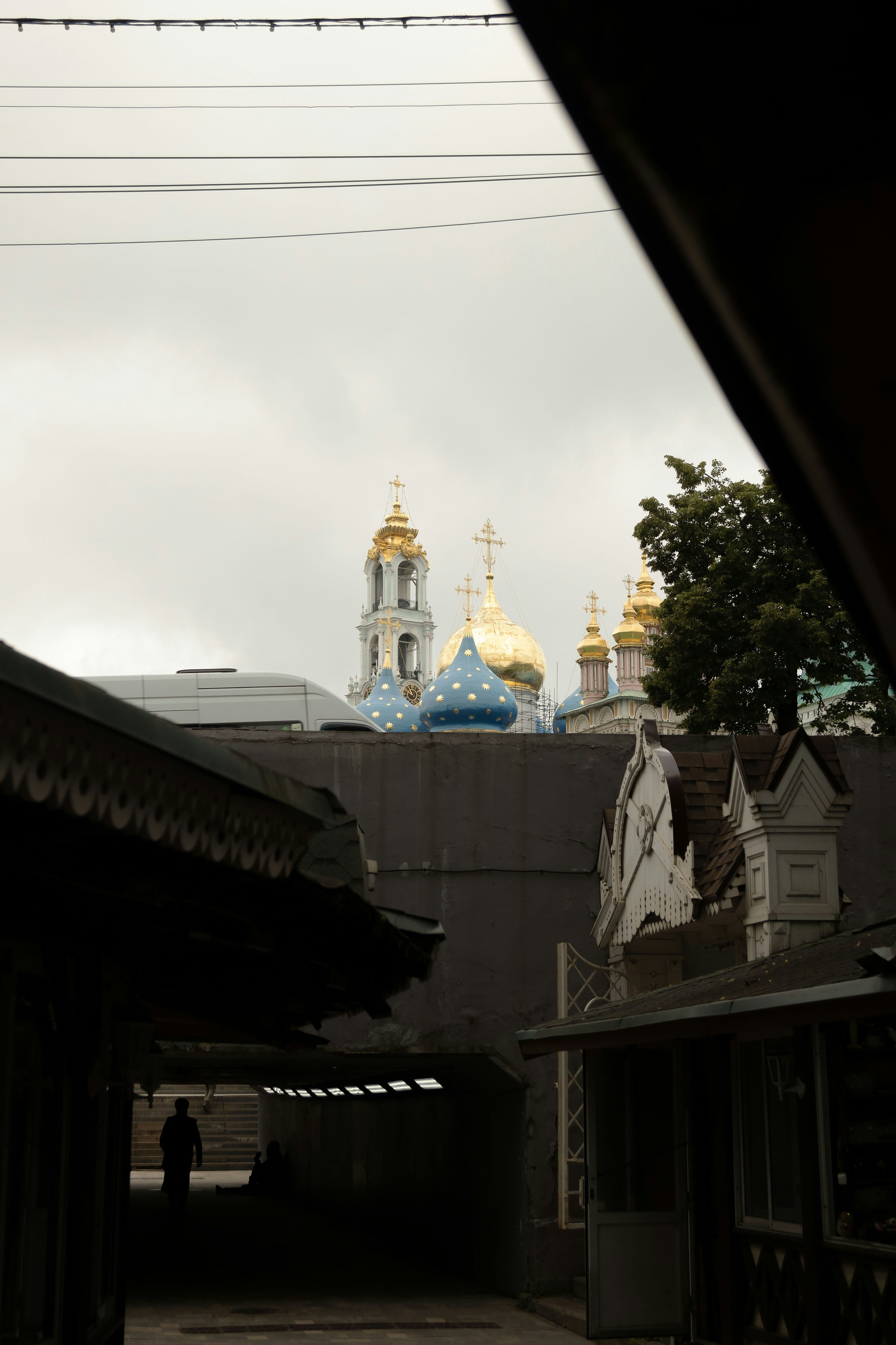 Blue domes and gilded crosses beyond a shadowed passage