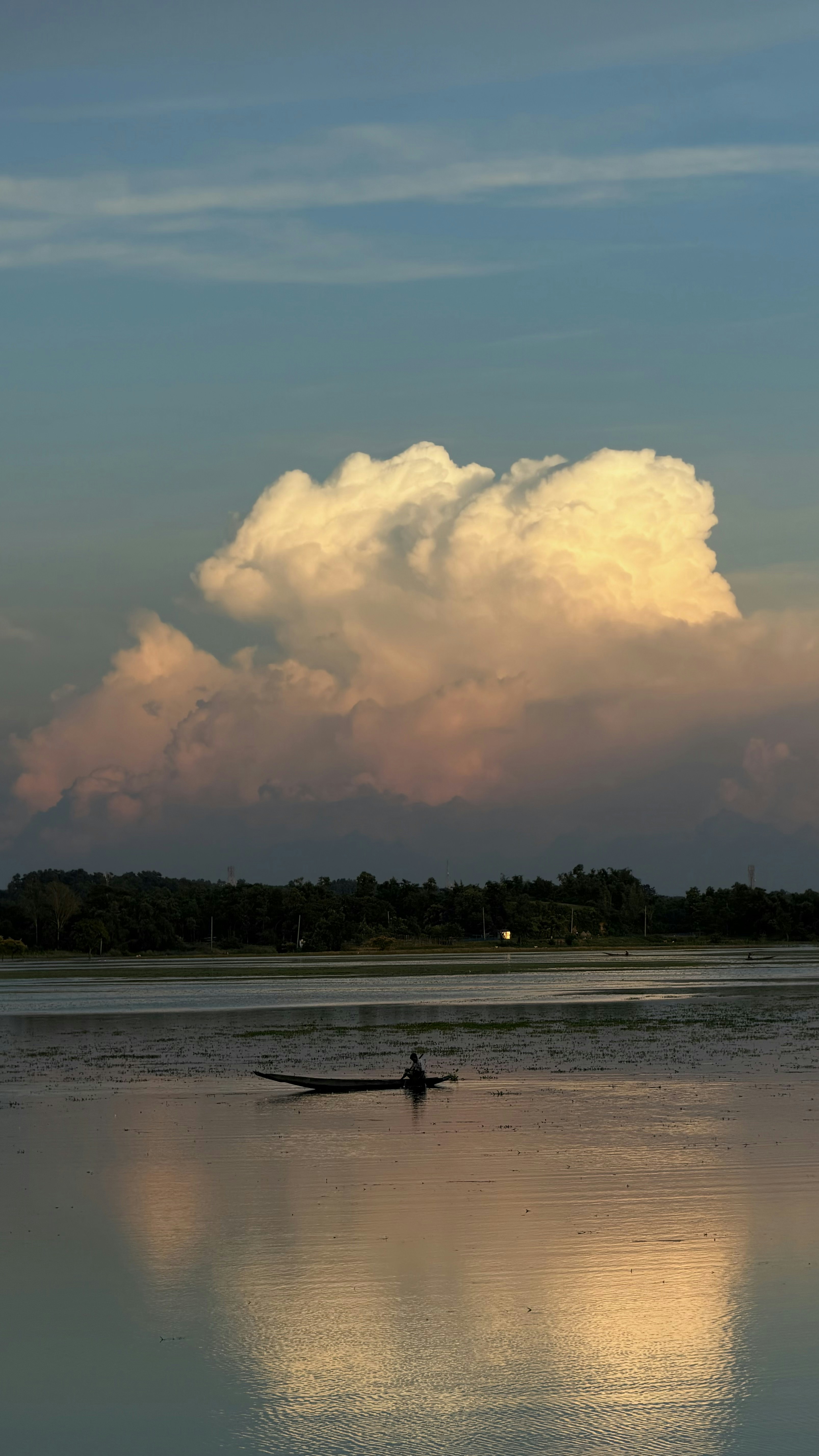 Cloudlit River Silence: A Lone Pirogue Across Evening Waters