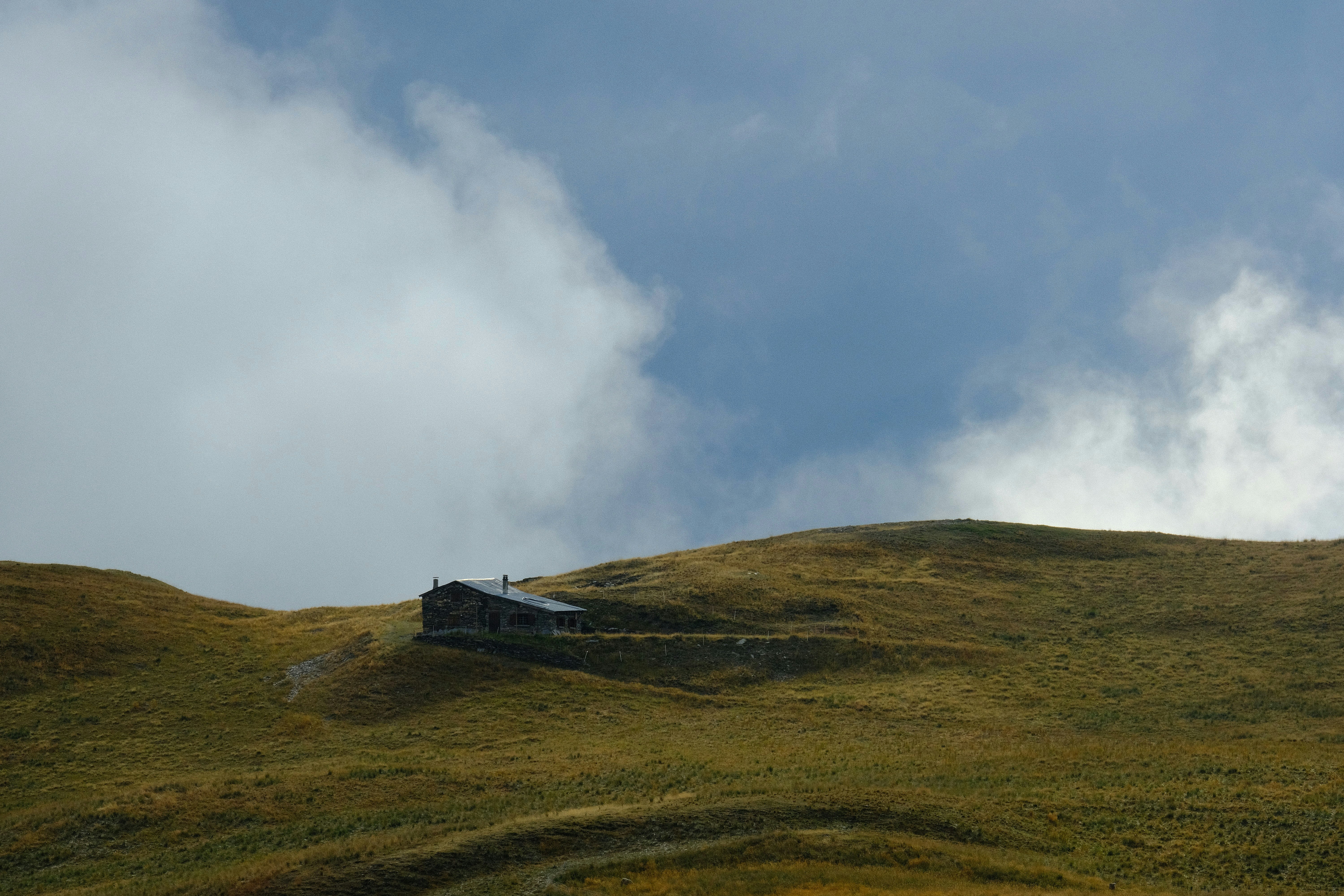 Hushed Horizon: A Lone Cabin on Rolling Moorlands