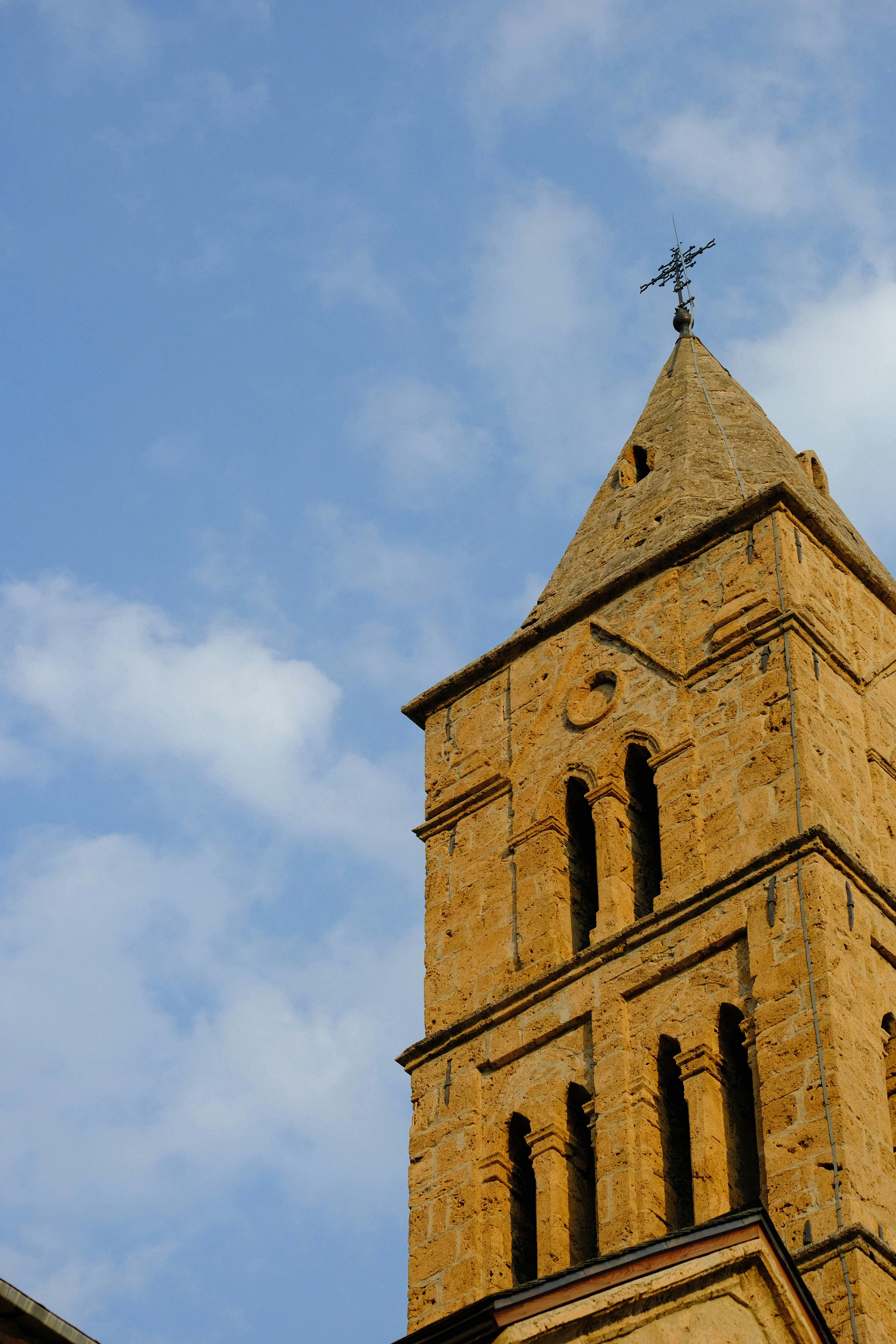 Towering Limestone Bell-Tower Reaching Toward a Bright Blue Sky