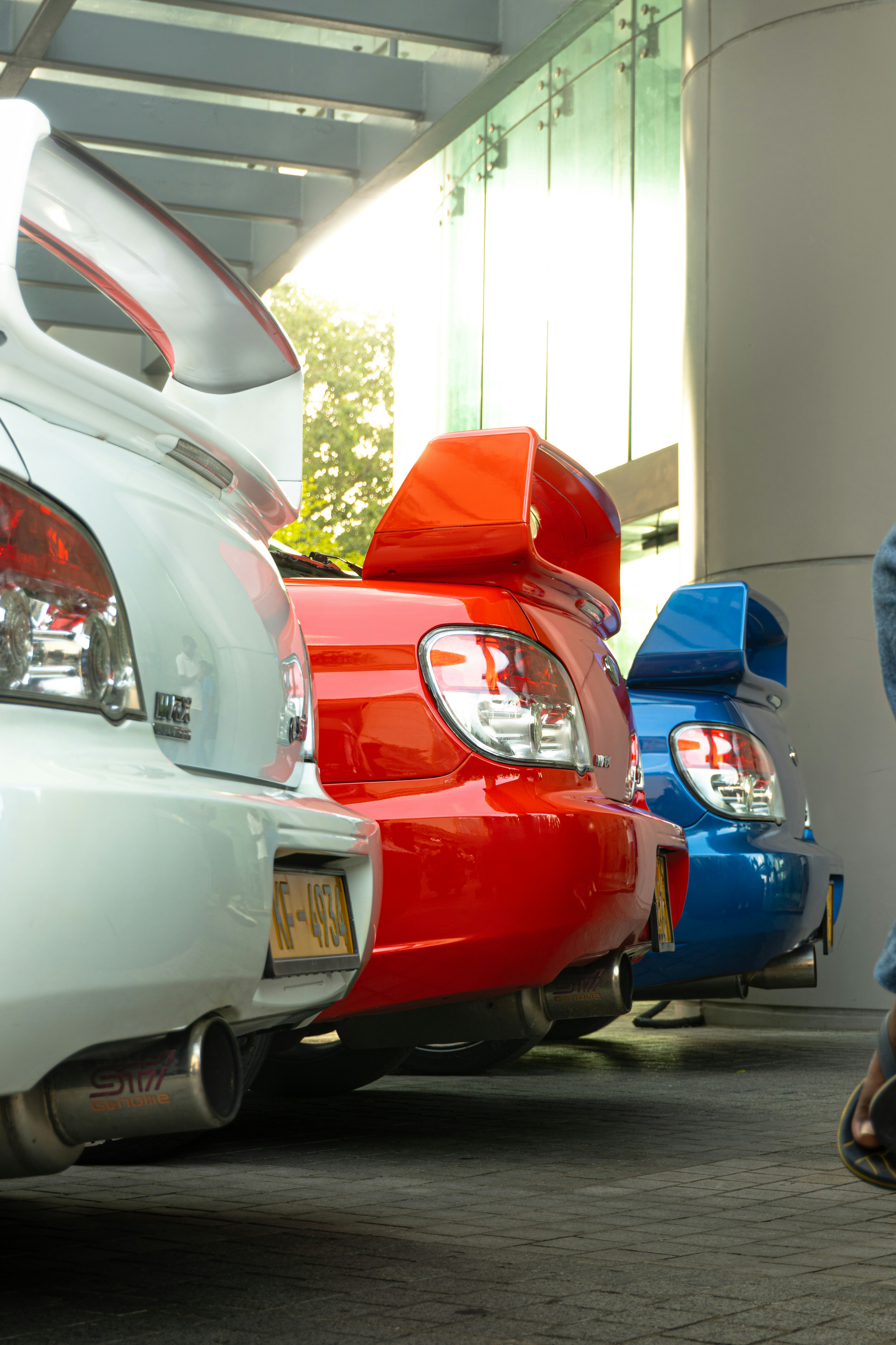 Three Colorful Rims: A Row of Hatchbacks at a Modern Car Show