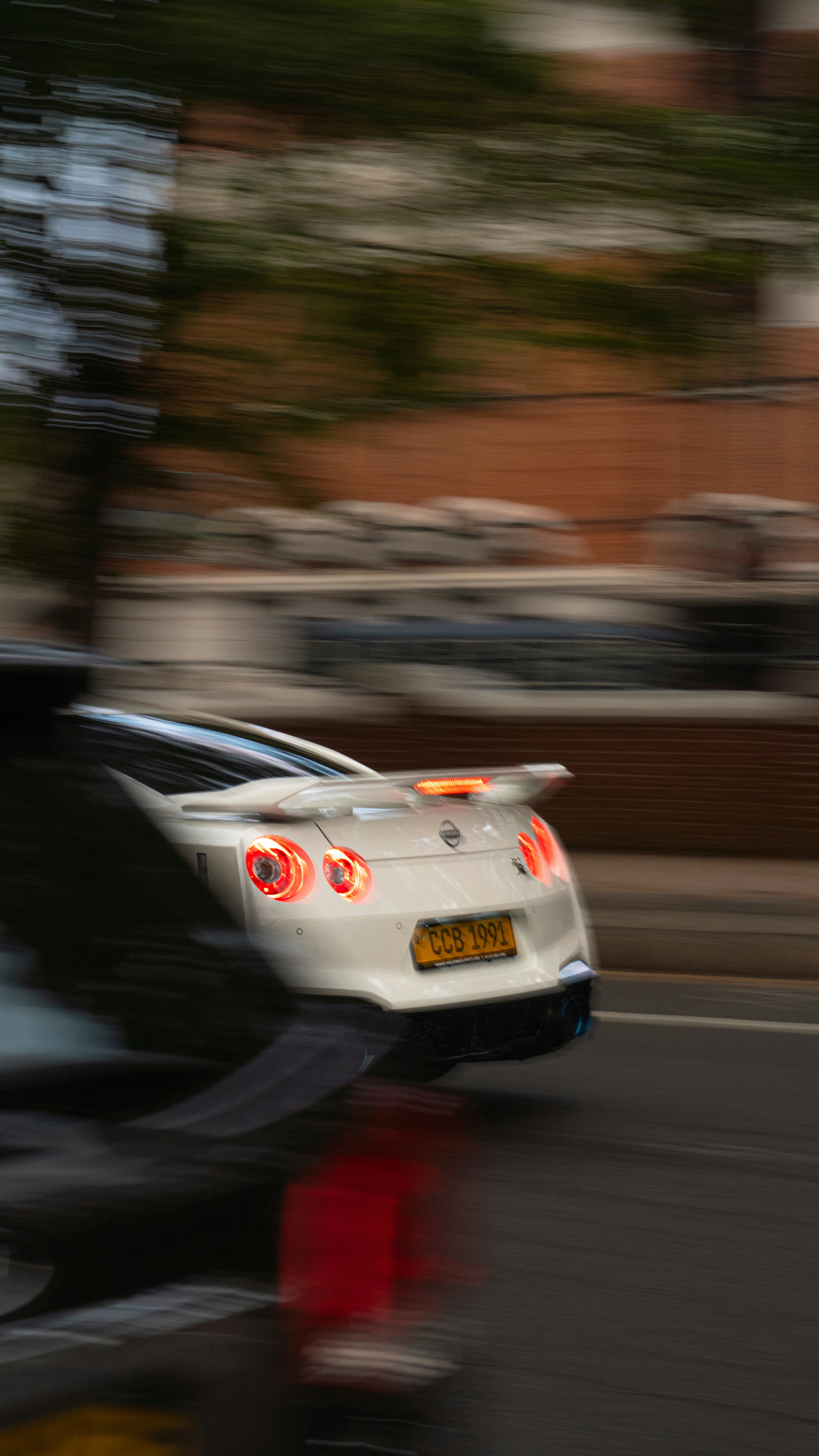 Last Tail Light: A White sports car darts through motion blur