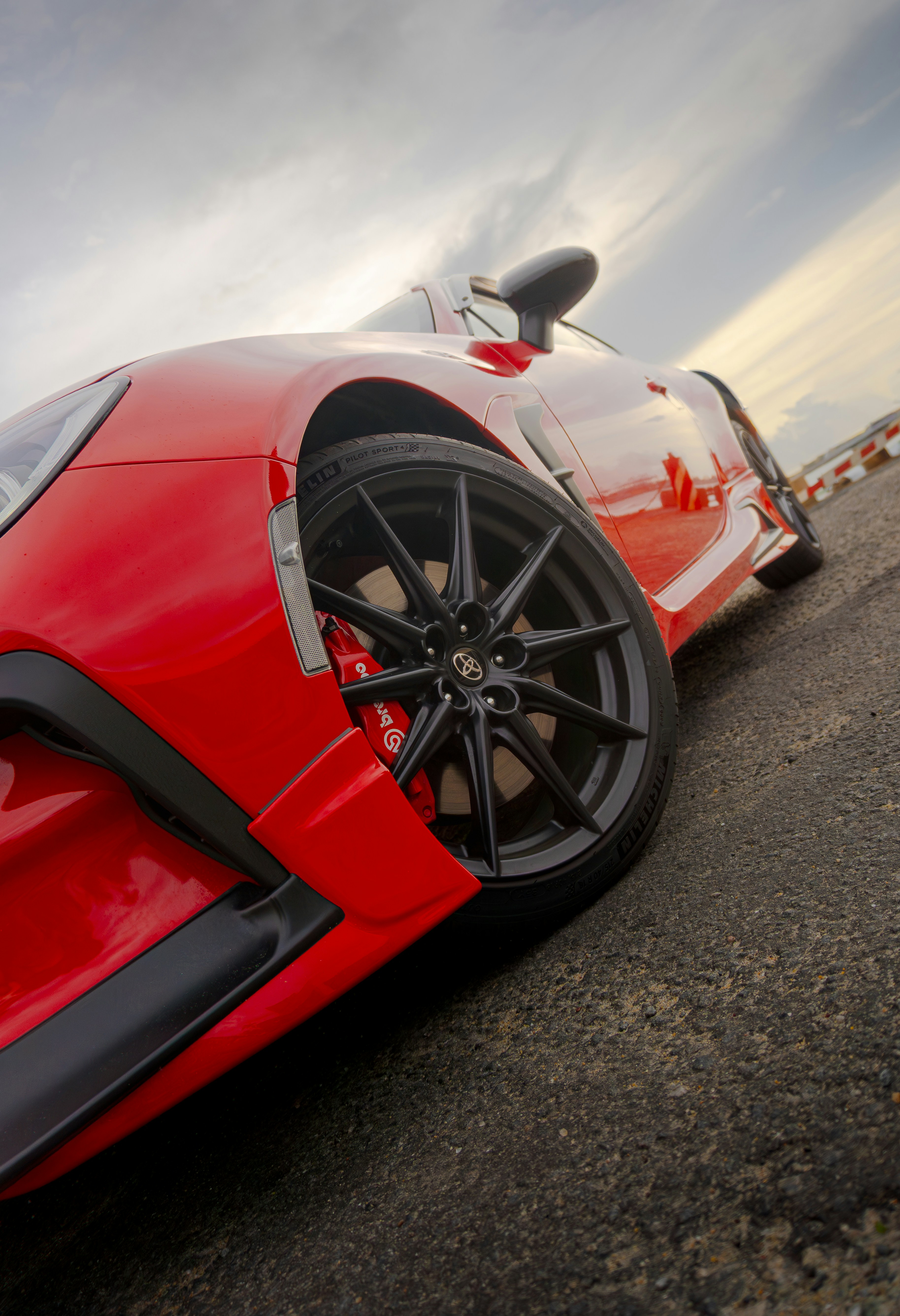 Red Apex: Close-Up of a Sportscar’s Wheel and Vented Fender