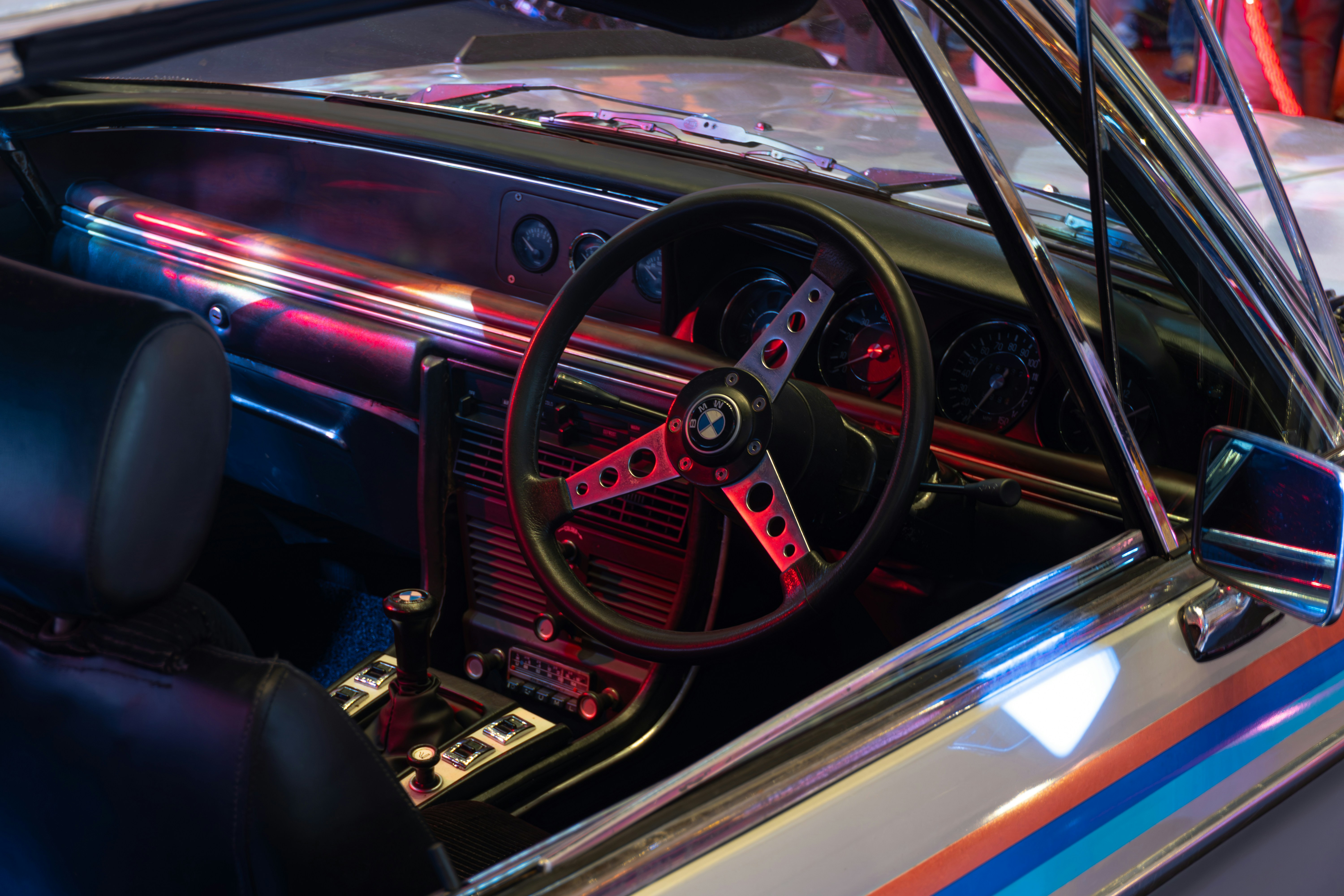 Chromed Nostalgia: A classic car’s cockpit under neon glow