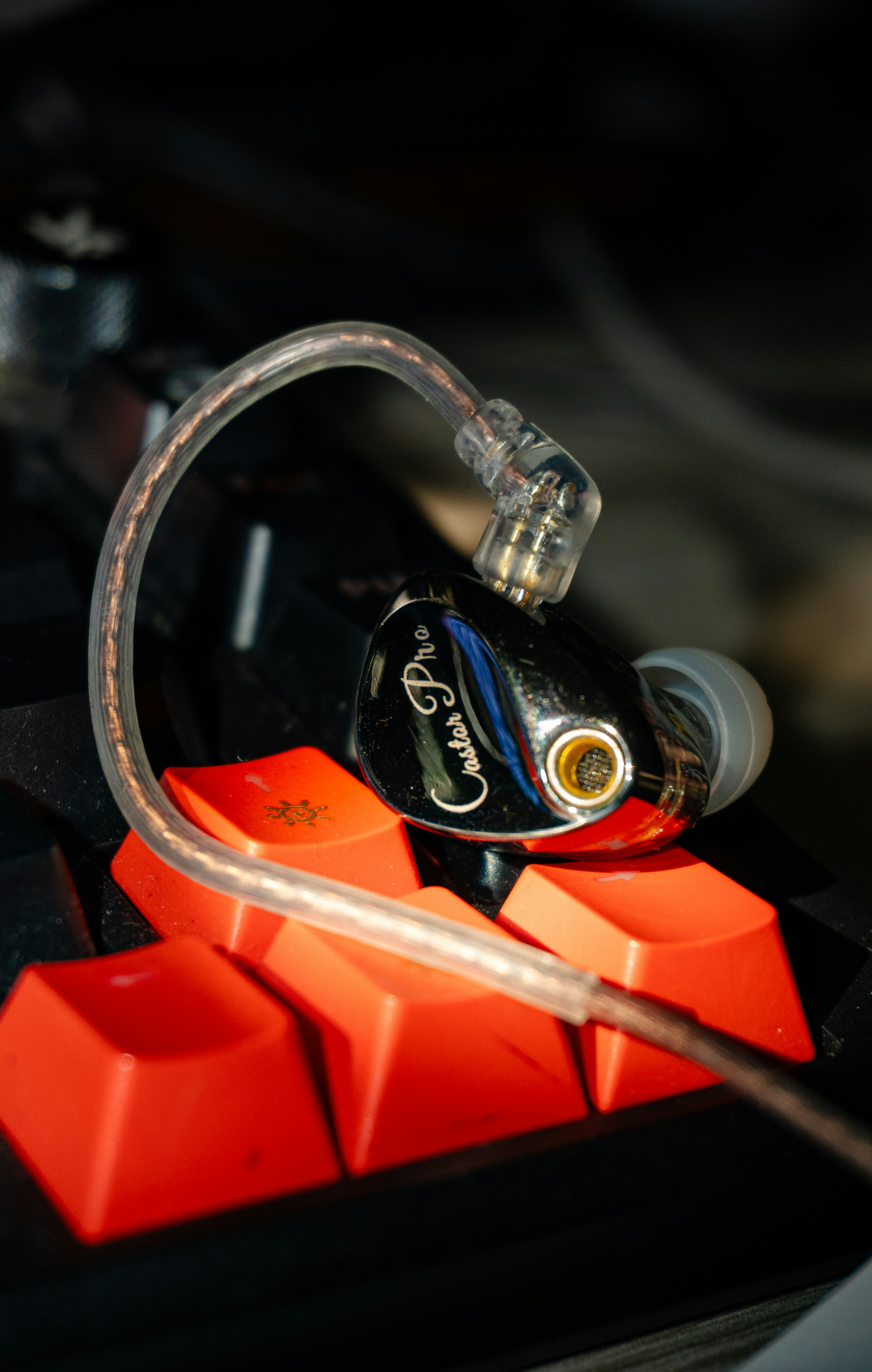 Gleaming Custom In-Ear Monitor Nestled on Bold Orange Cushions
