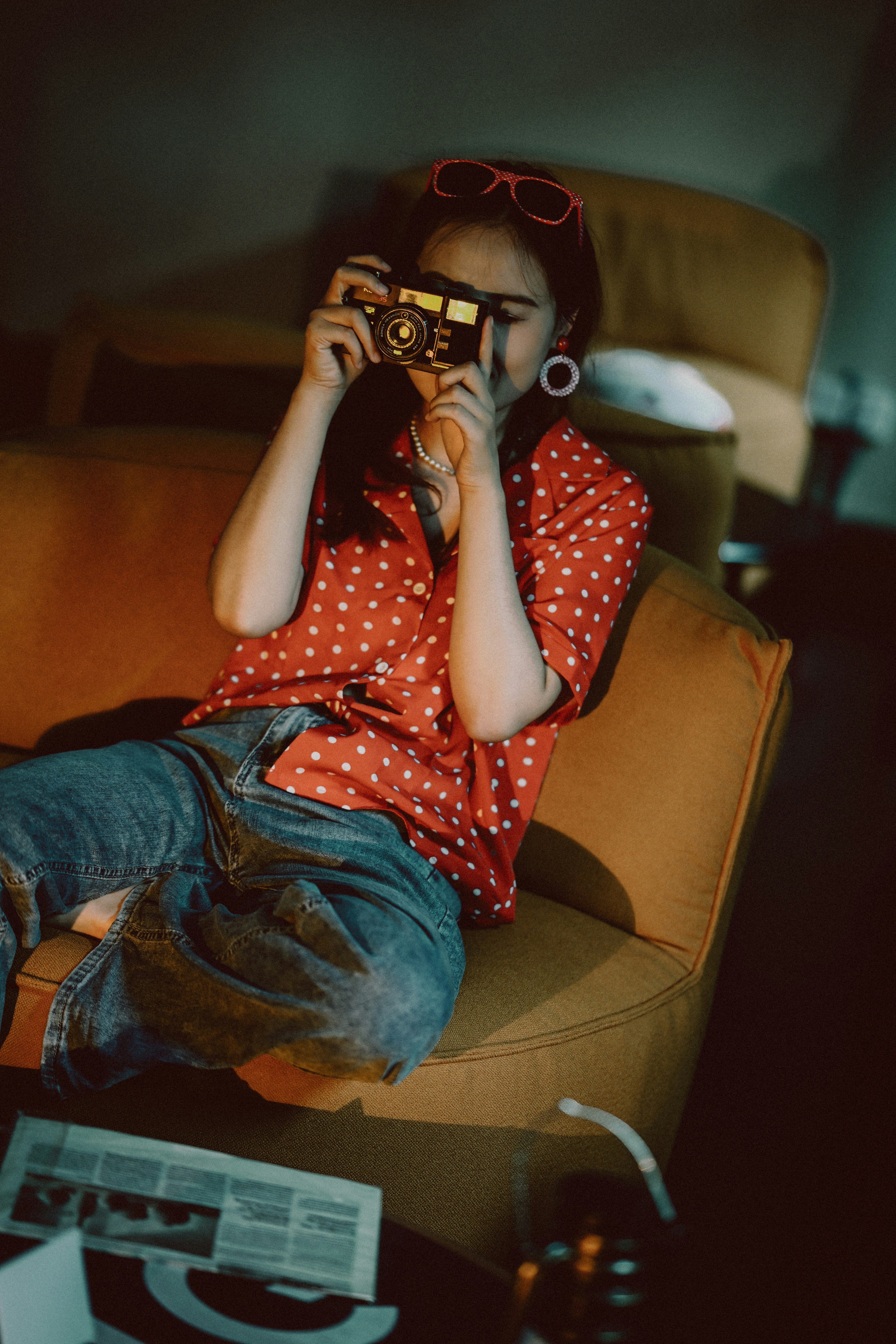 Midnight Portrait: A Girl with Vintage Camera on a Cozy Couch
