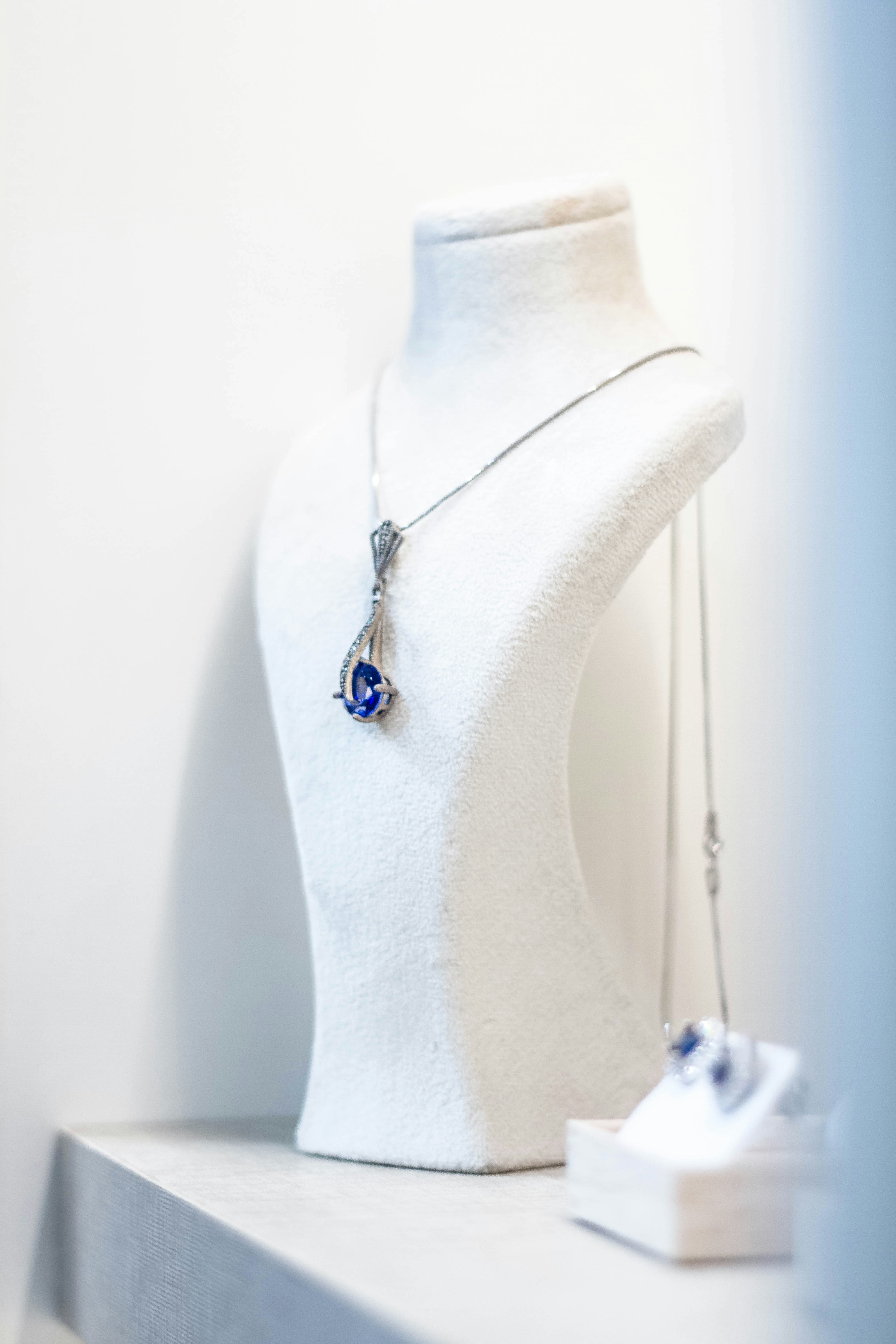 Blue sapphire pendant on a minimalist jewelry display
