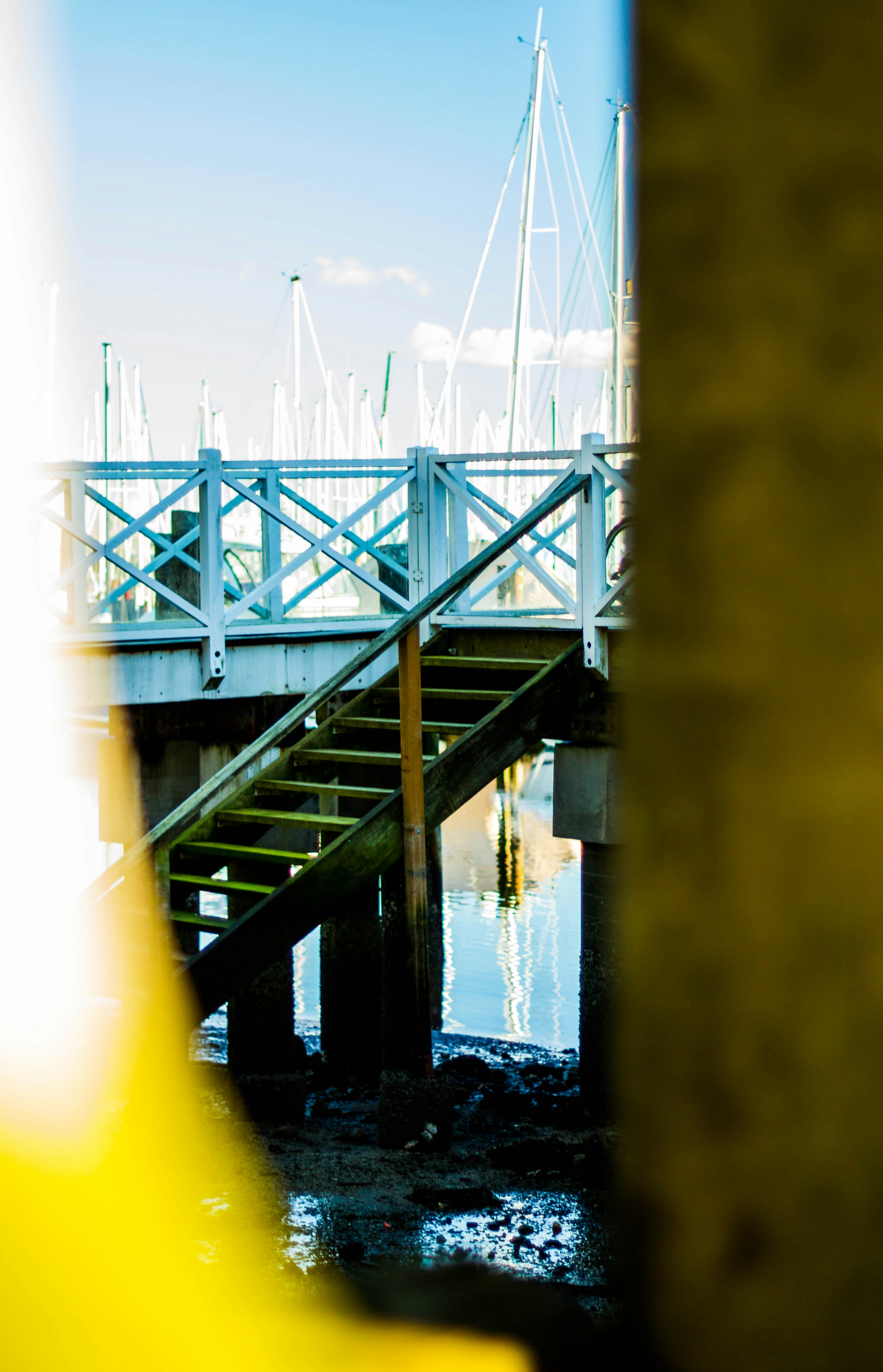 Bridge Framed Between Yellow and Shadowed Pillars at Waterfront