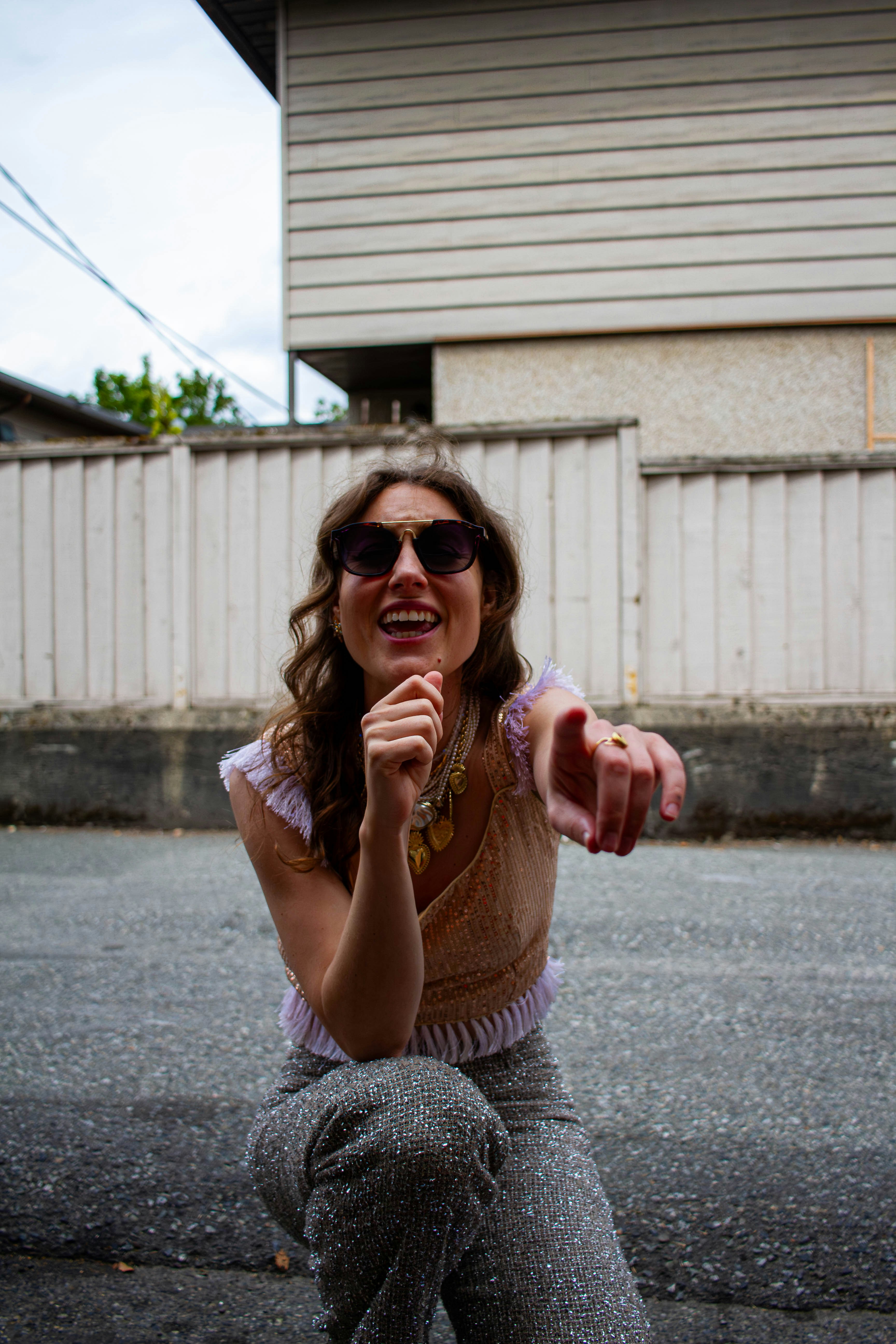Laughing Youth in Sunglasses Reaches Forward in a Sunlit Alleyway