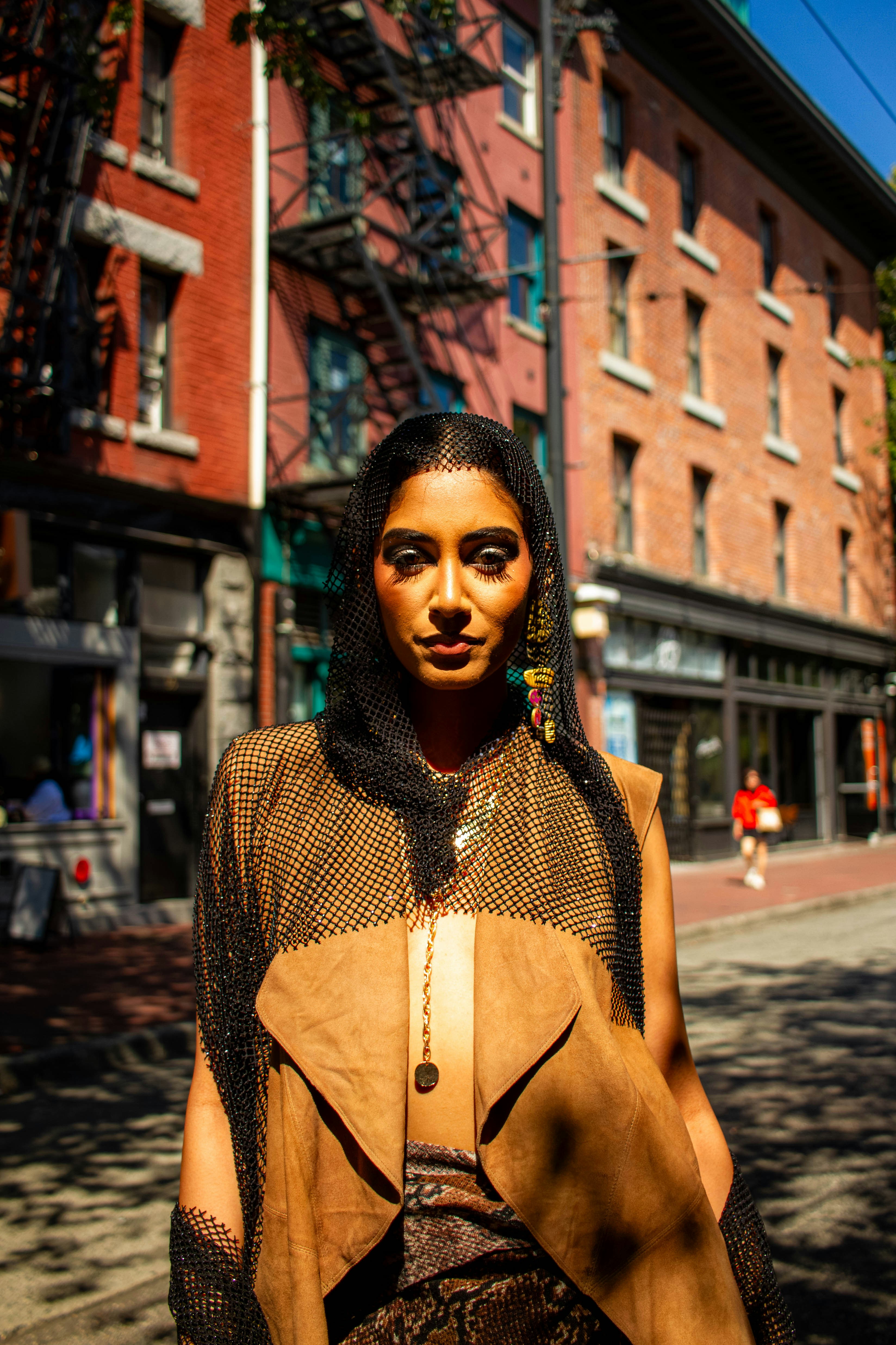 Netted veil, warm tones: a street portrait in afternoon sun