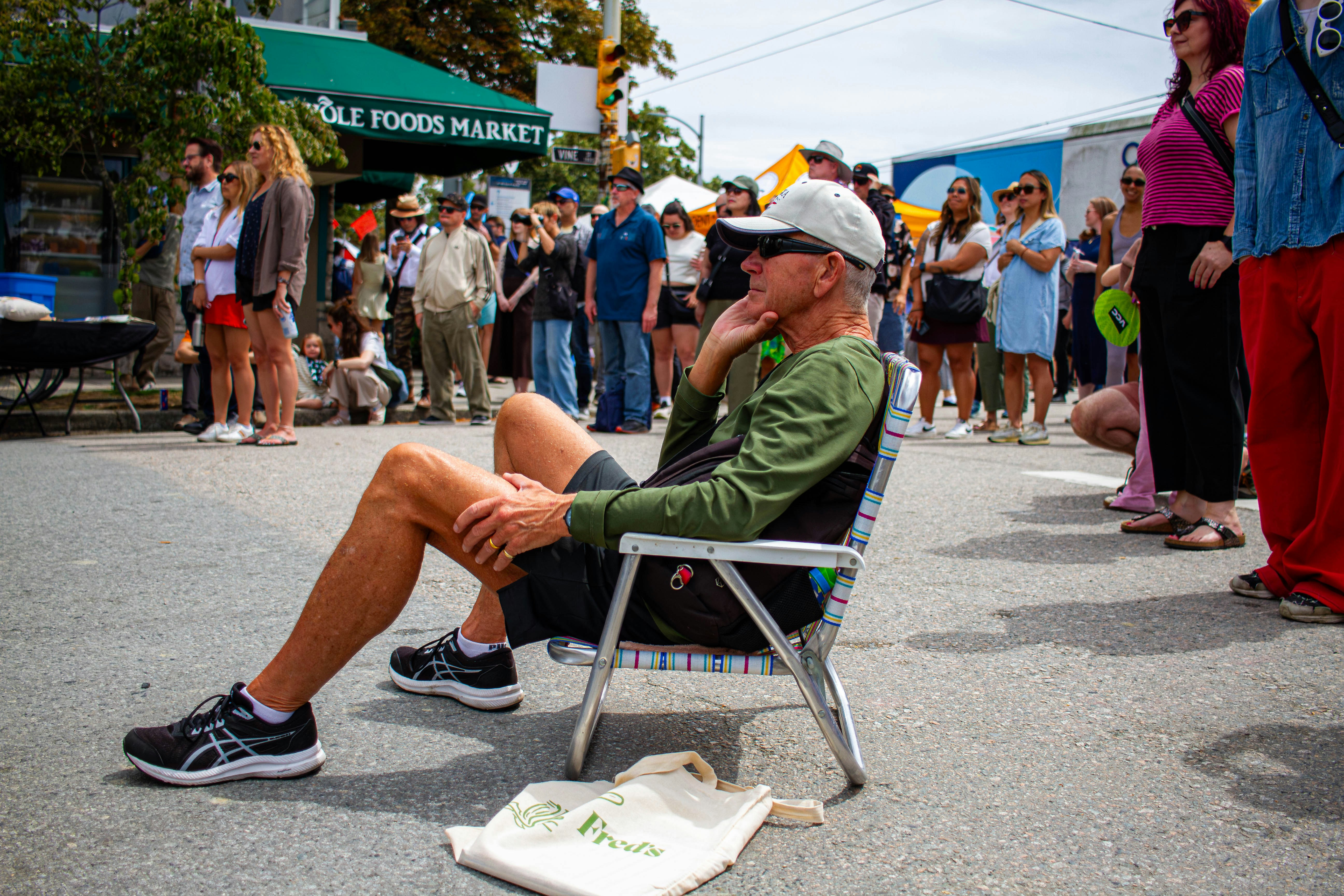 Chill Spotlight: A Street Offeror in a Quiet Moment Amid a Summer Crowd