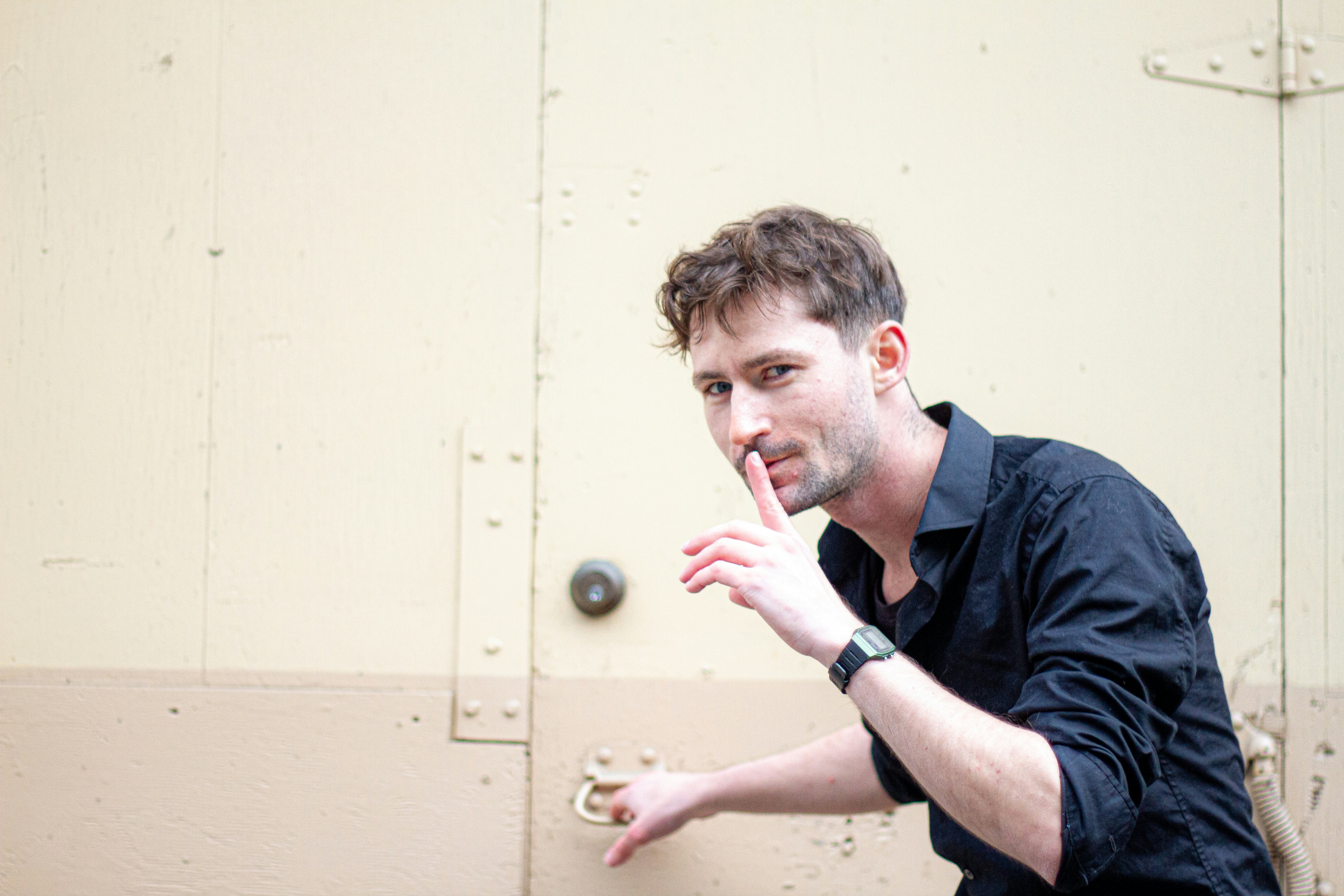 Shushing Gesture: A Quiet Portrait Against a Quiet Wall