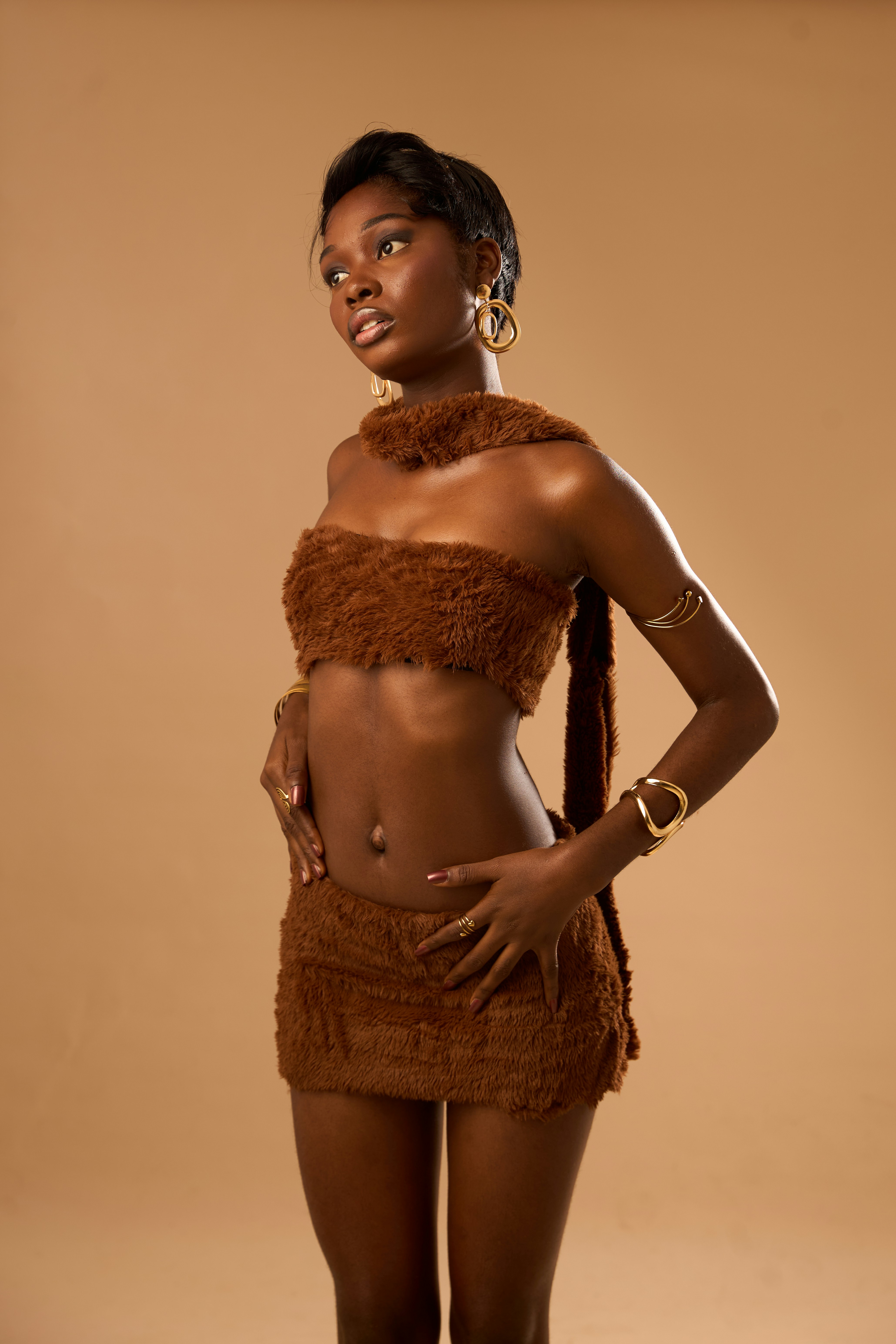 Brown velvet two-piece: poised elegance against a warm studio glow