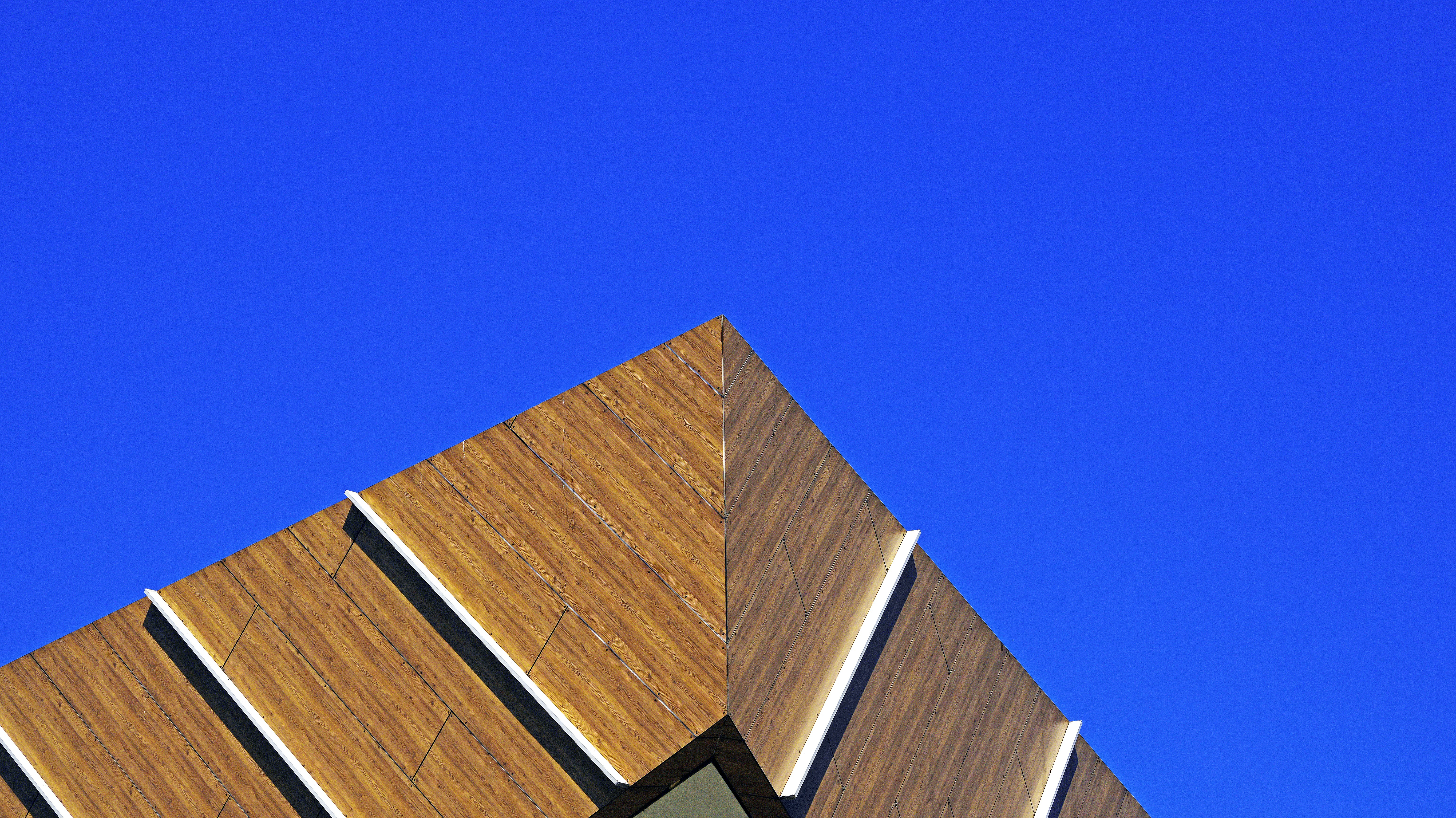 Angles of Timber: A Sharp Facade Against a Clear Sky