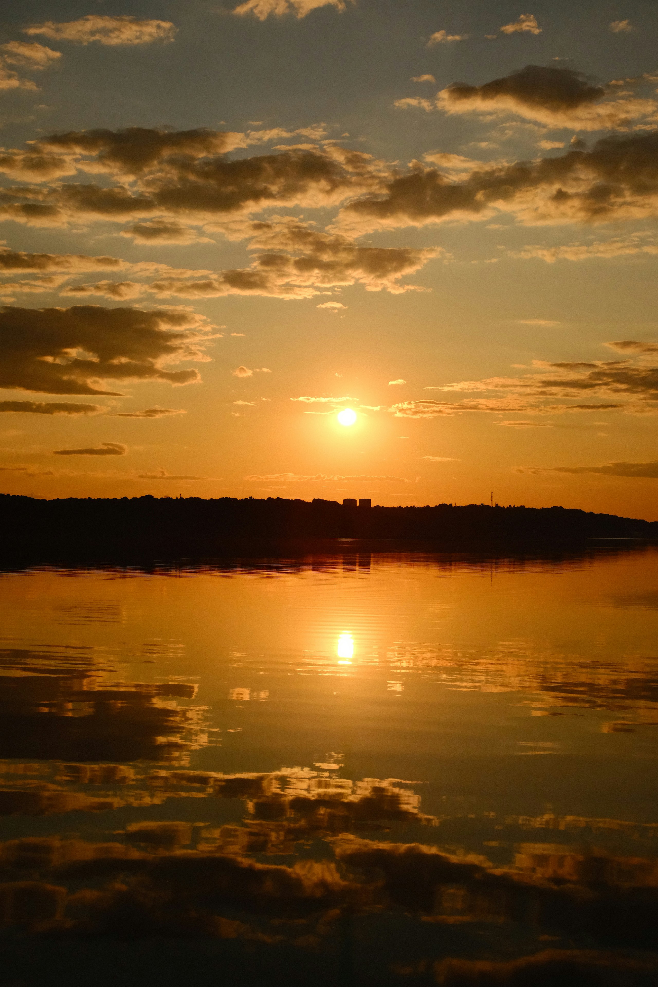 Silhouetted Horizon at Golden Hour Over a Mirror Calm