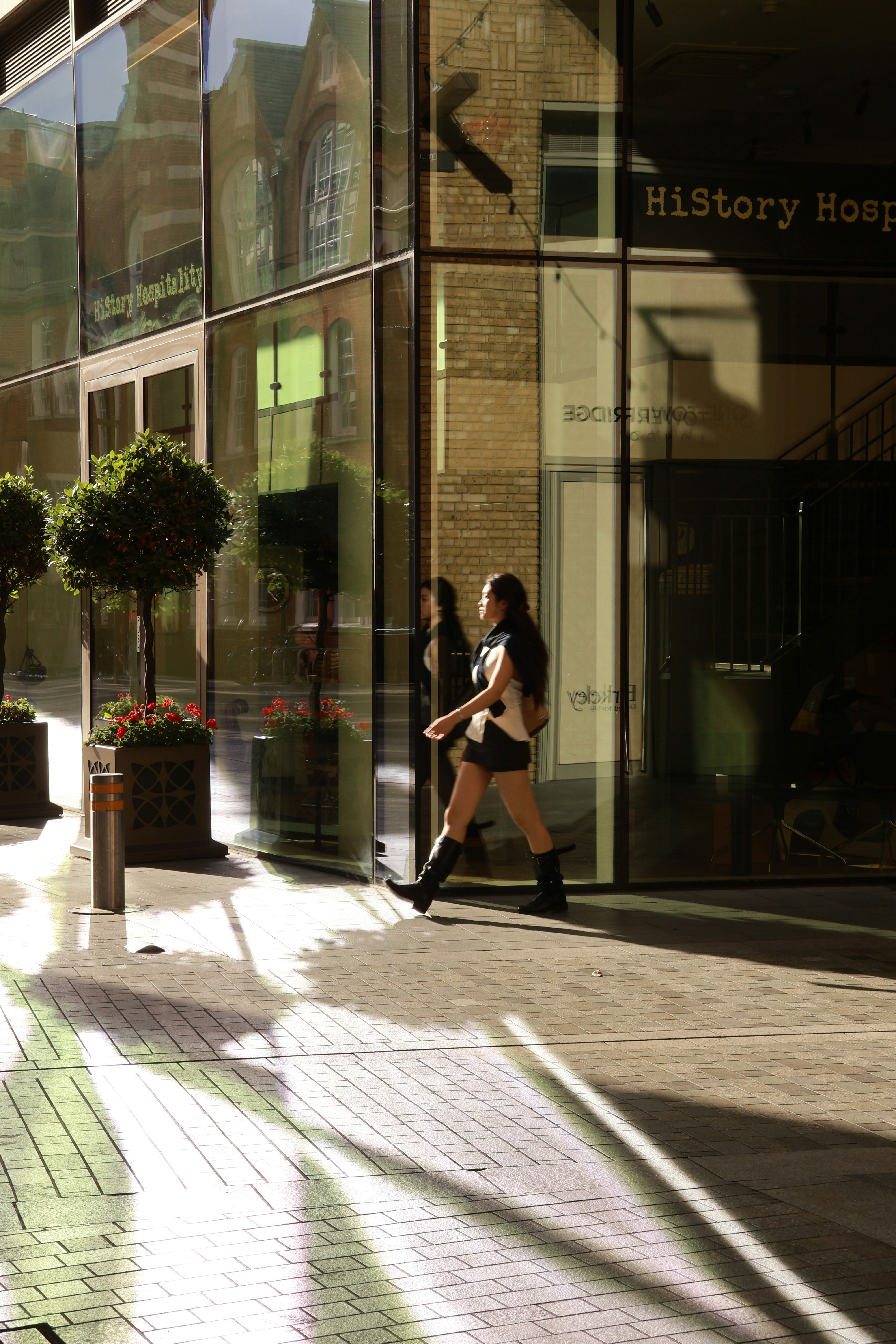 Passing Through Light: A Morning Stroll by the Glass Facade