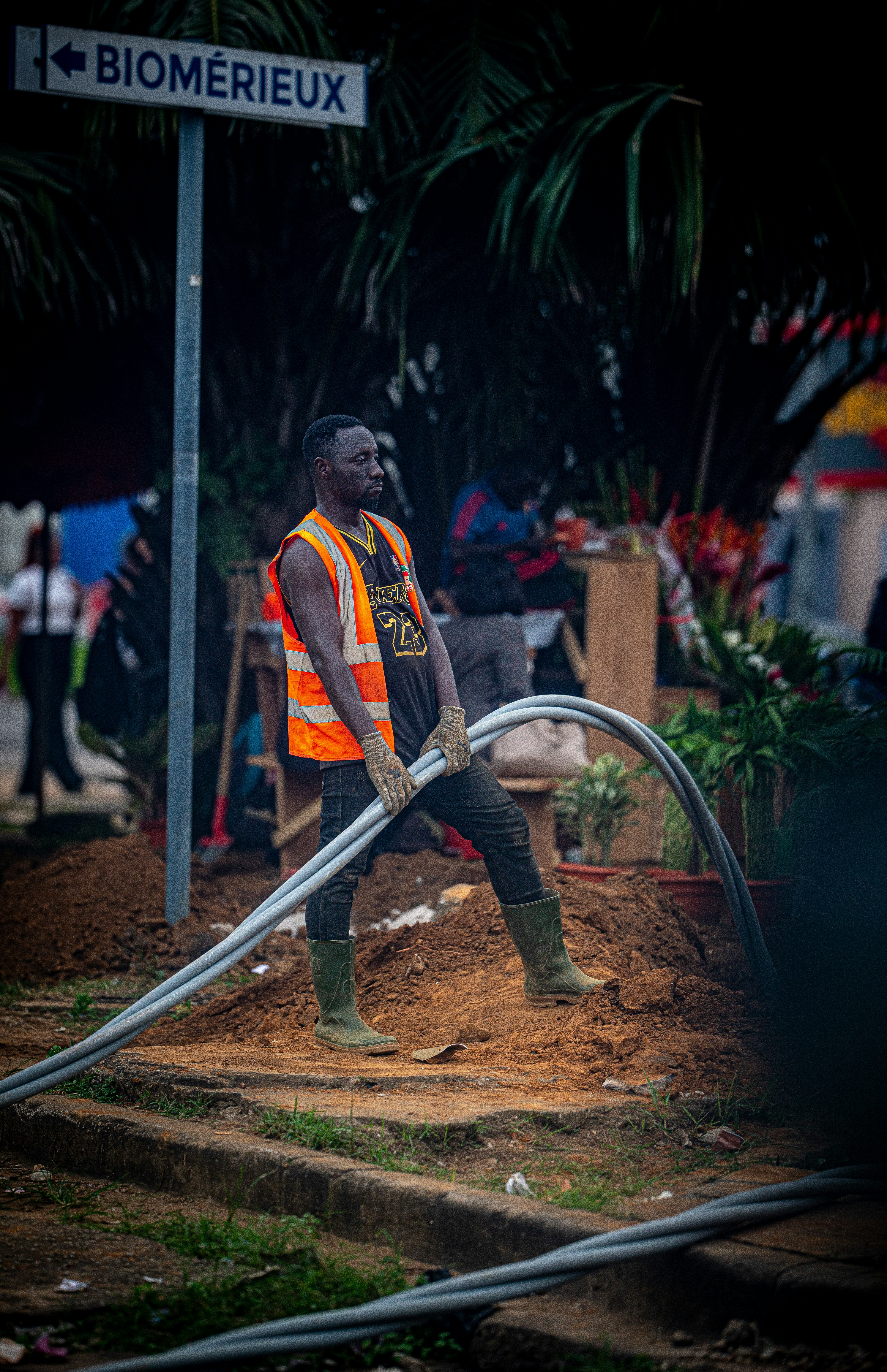 Strongman in High-Visibility Vest at a Construction Site Signpost