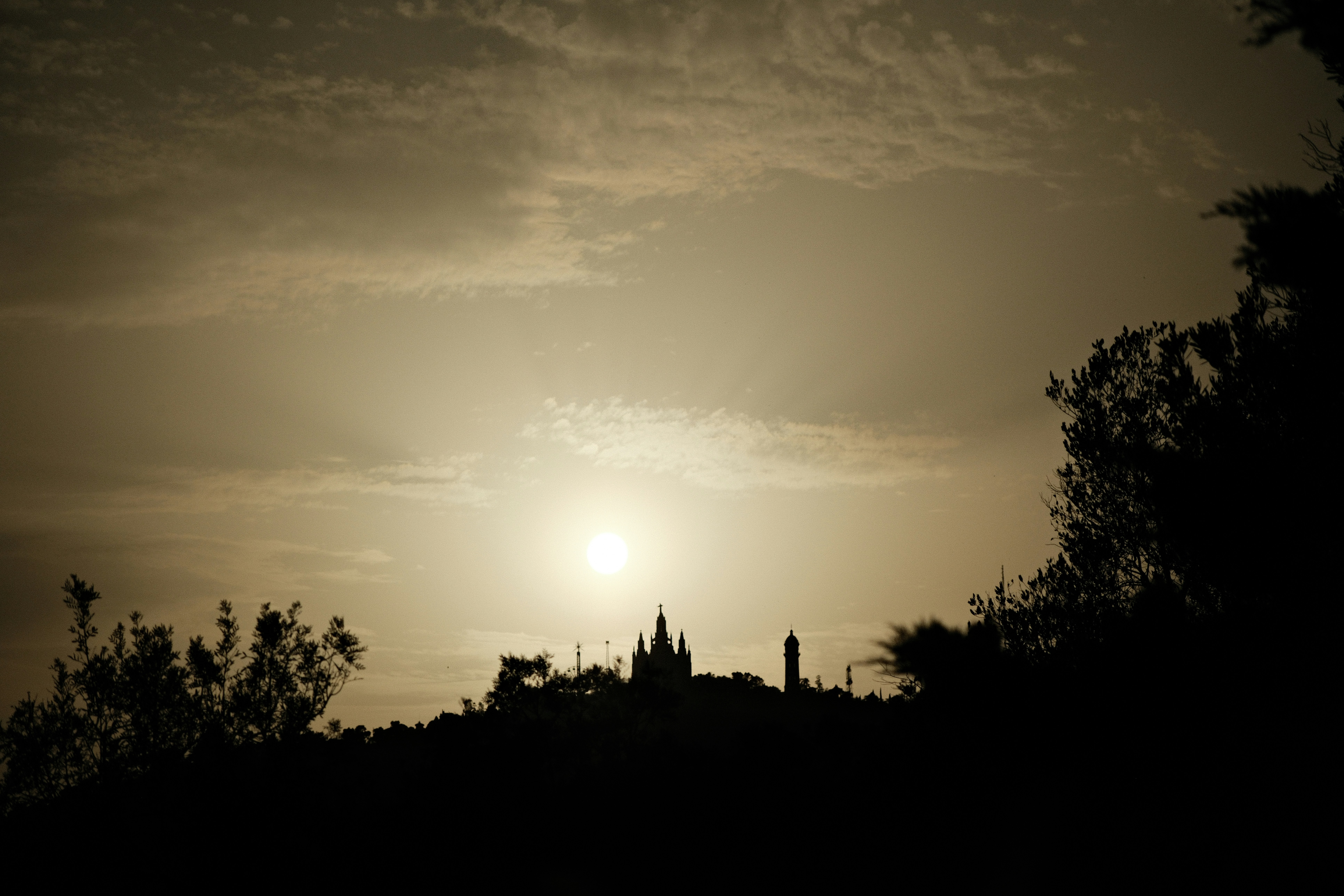 Silhouette at Sunset: City Spire Against a Golden Horizon