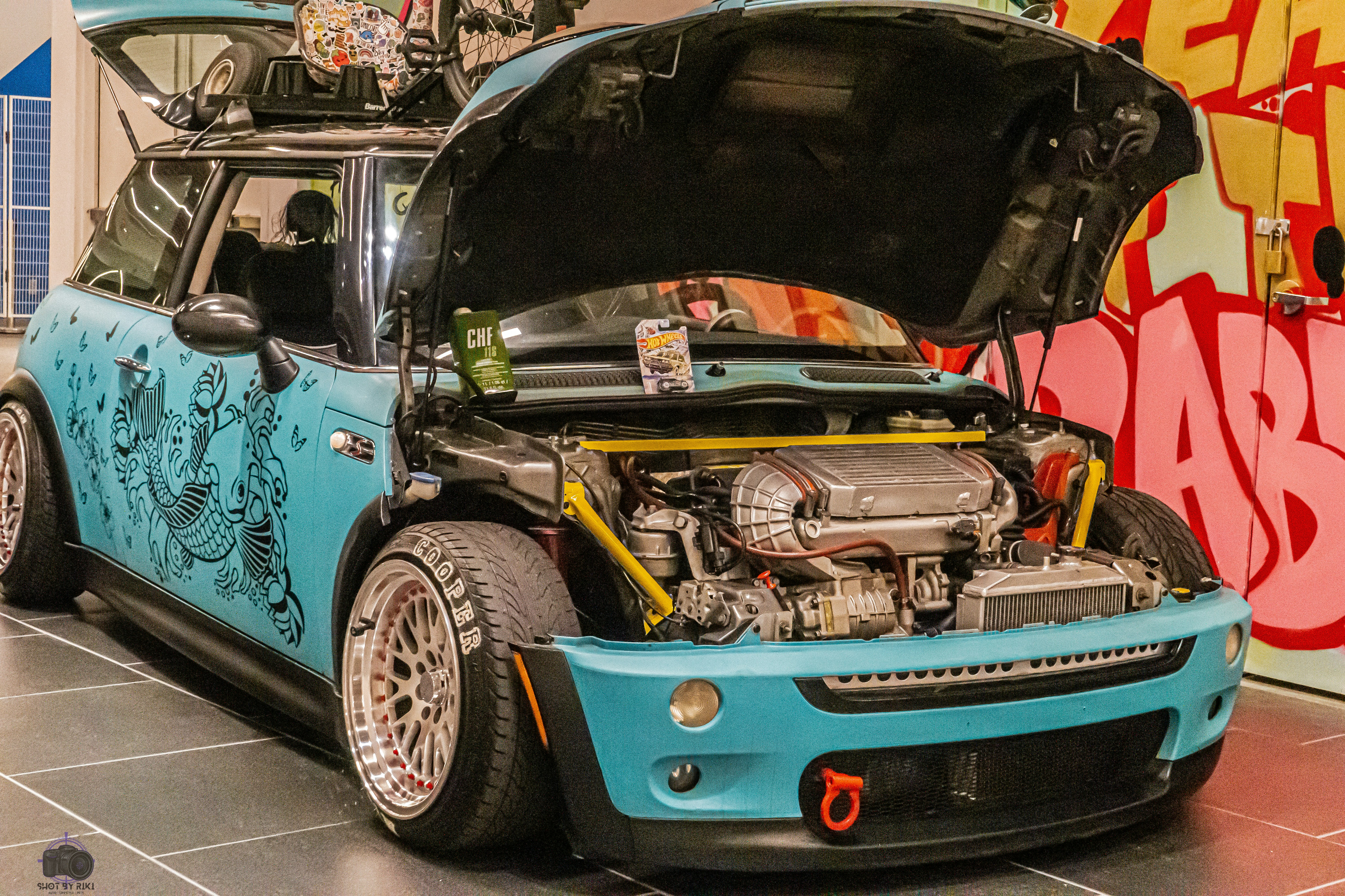 Turbo-tuned teal hatchback under showroom lights