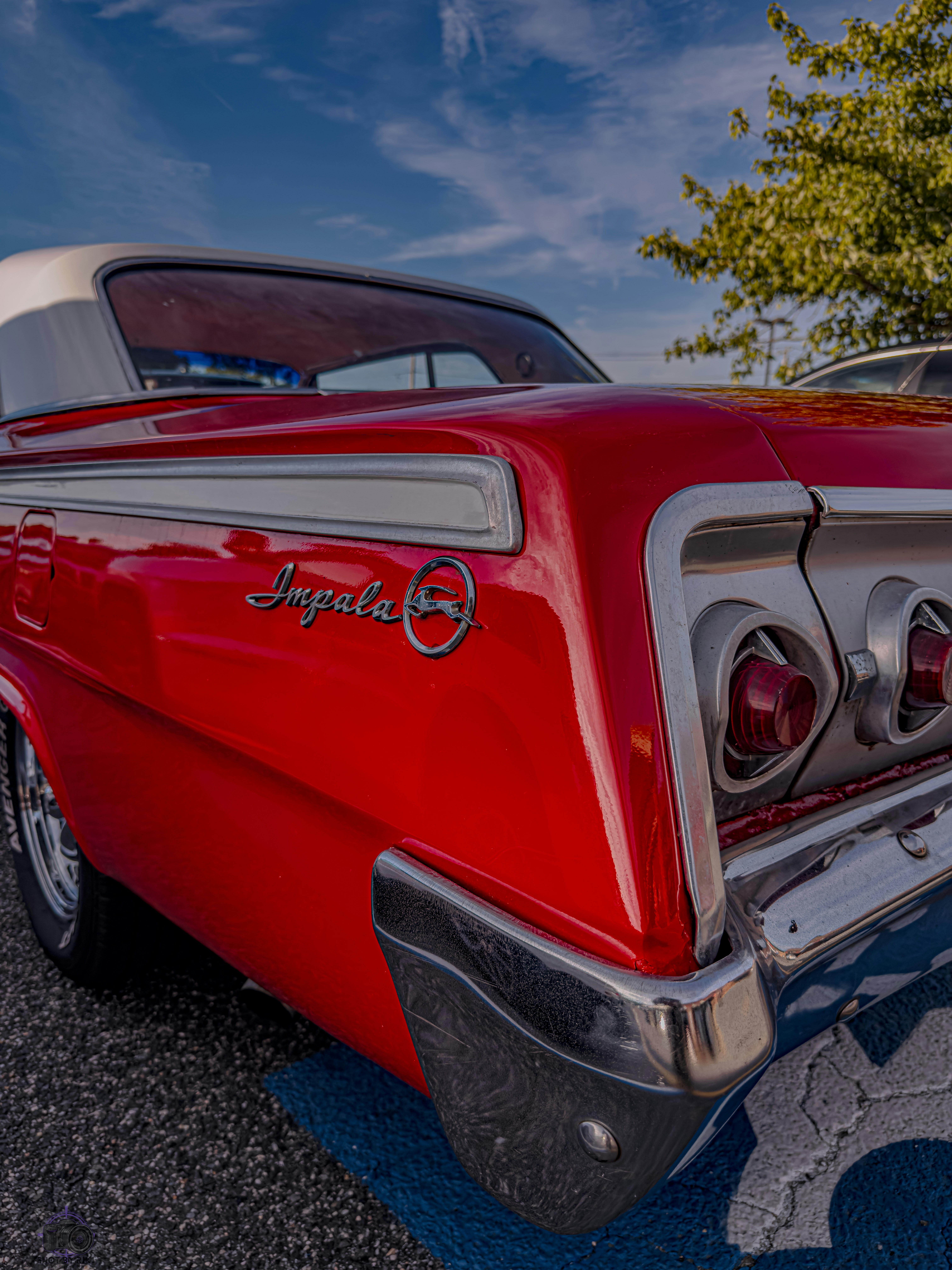 Shiny chrome and crimson curves: a vintage Impala tailfin close-up