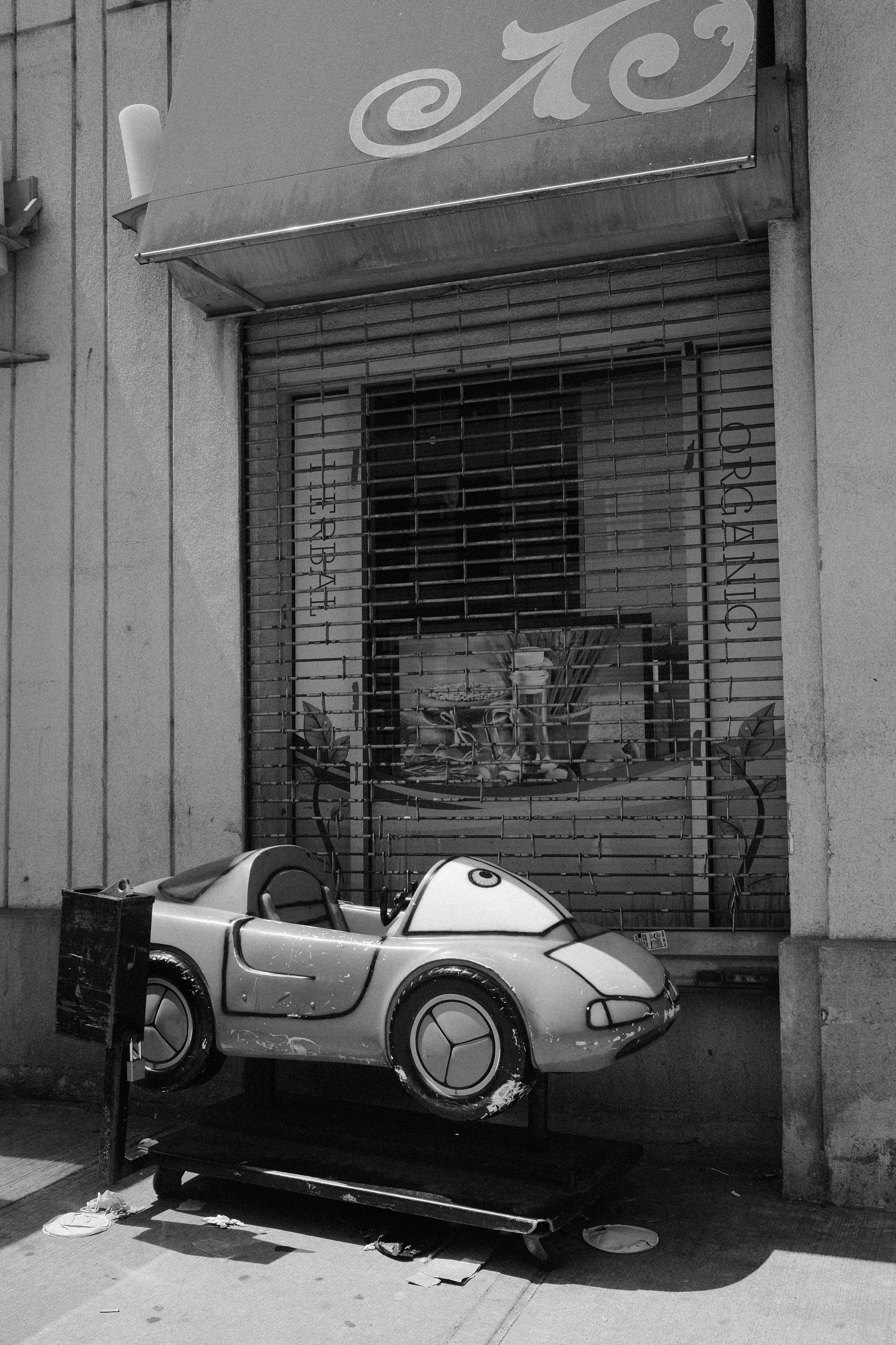 Shuttered showroom toy car on a quiet street