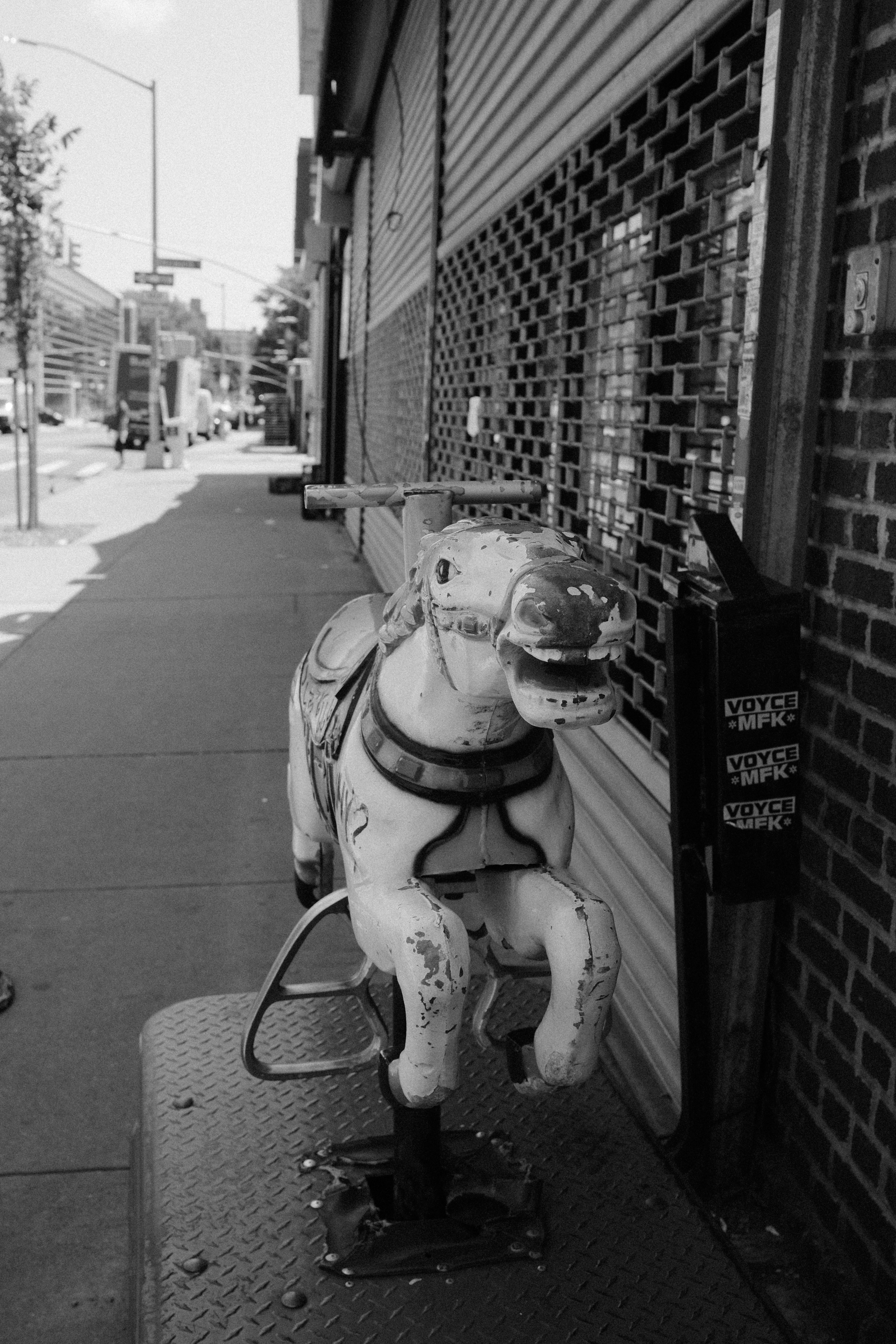 Silent Street Guardian: The Weathered Carousel Horse Stands Watch