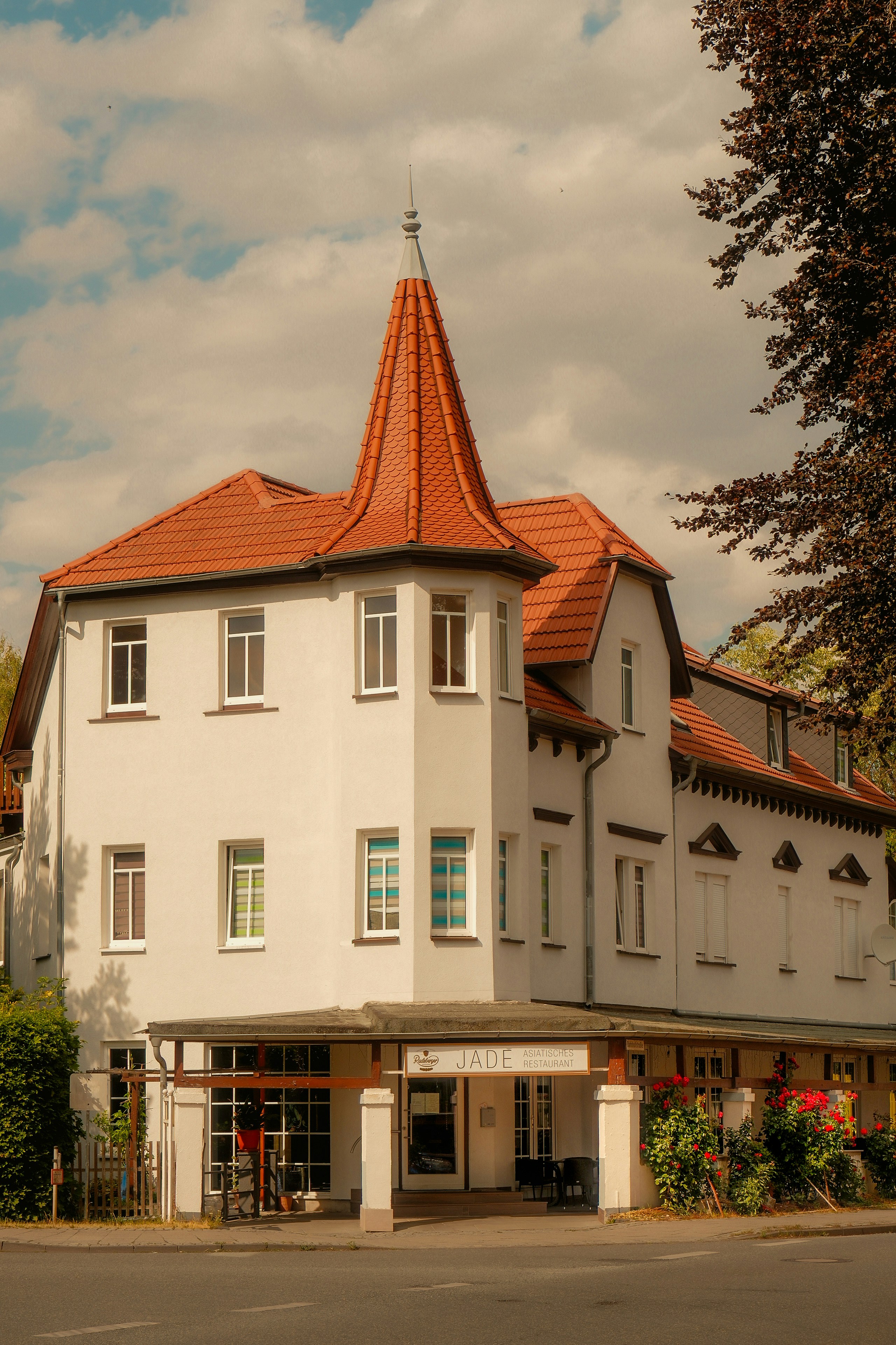 The Red-Topped Facade: A Corner Hotel with Towering Roofs