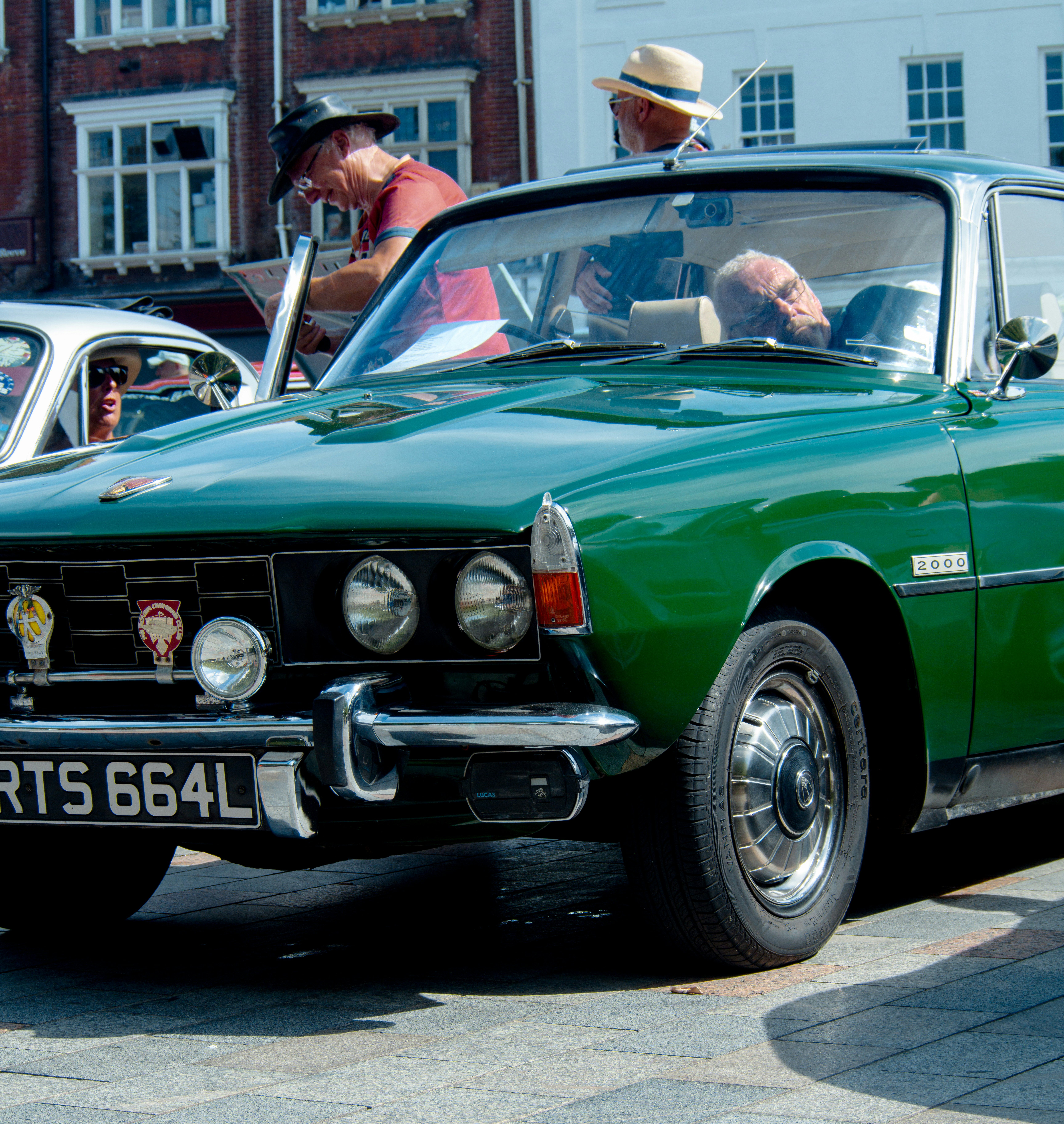 Emerald Classic: A stately green classic car with chrome details and bystanders aboard