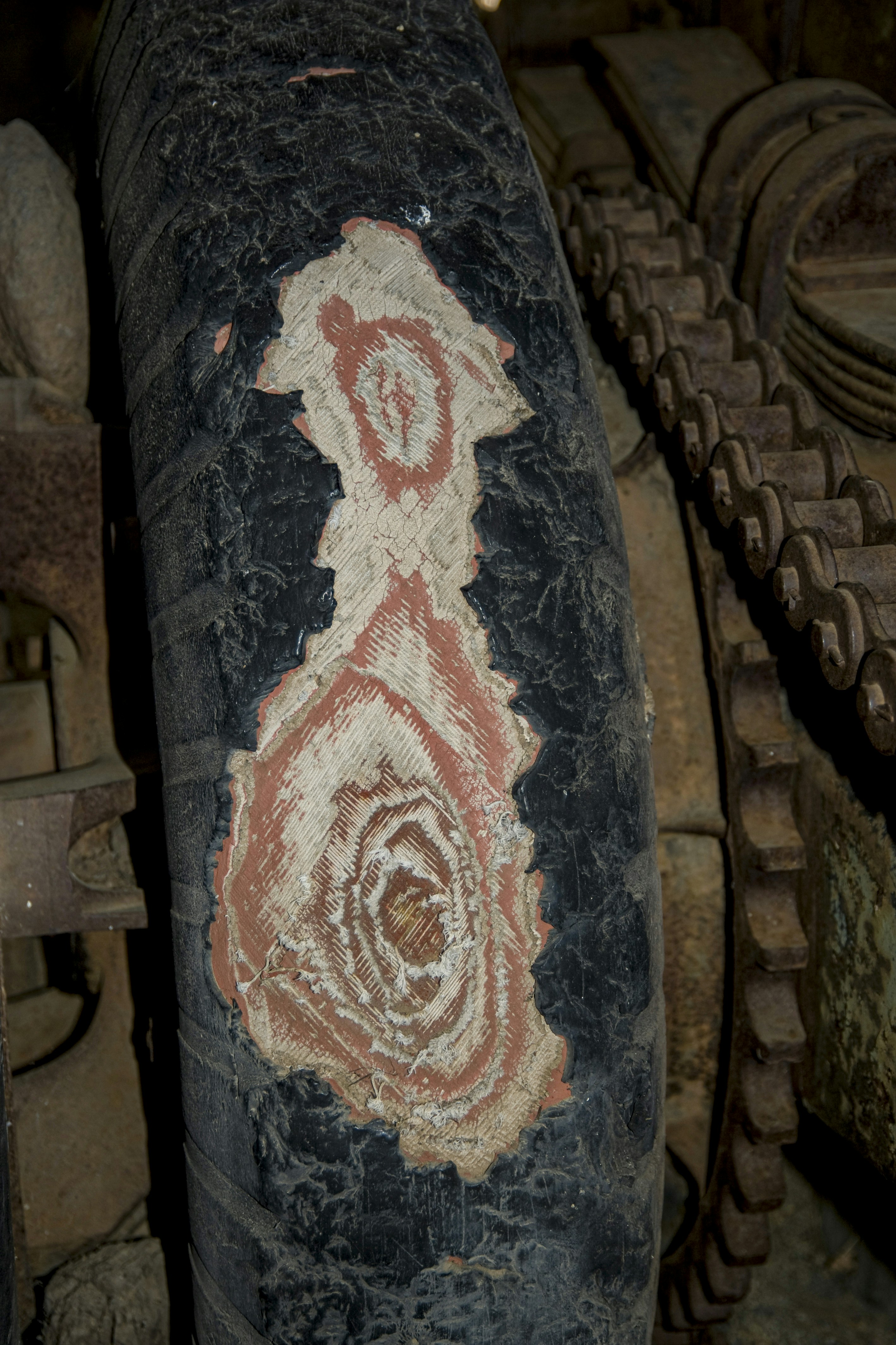 Weathered Tire on Rusted Machinery: A Field of Chains and Oil-Streaked Metal