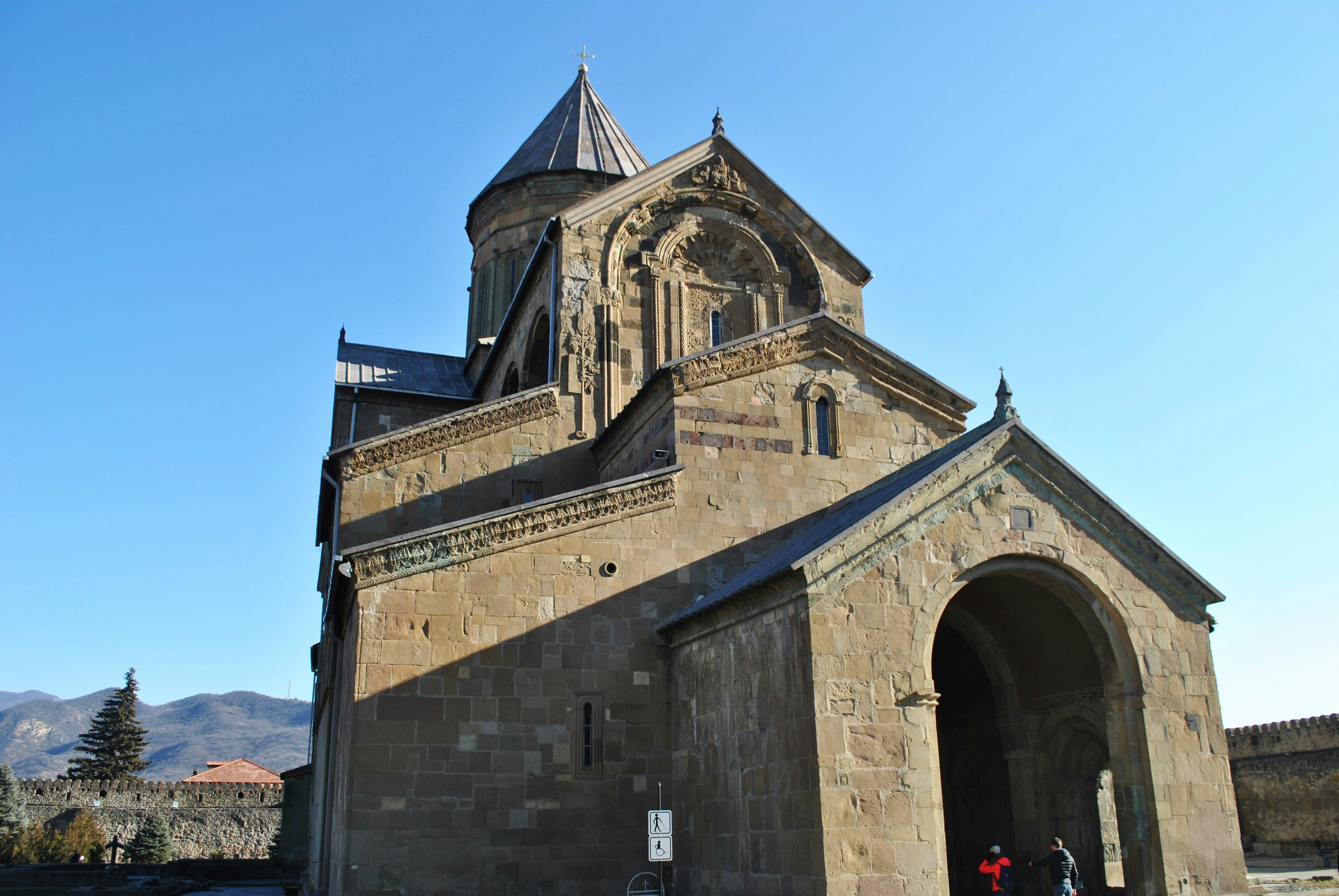 Stone Abbey Rising: A Byzantine-inspired facade under a clear alpine sky