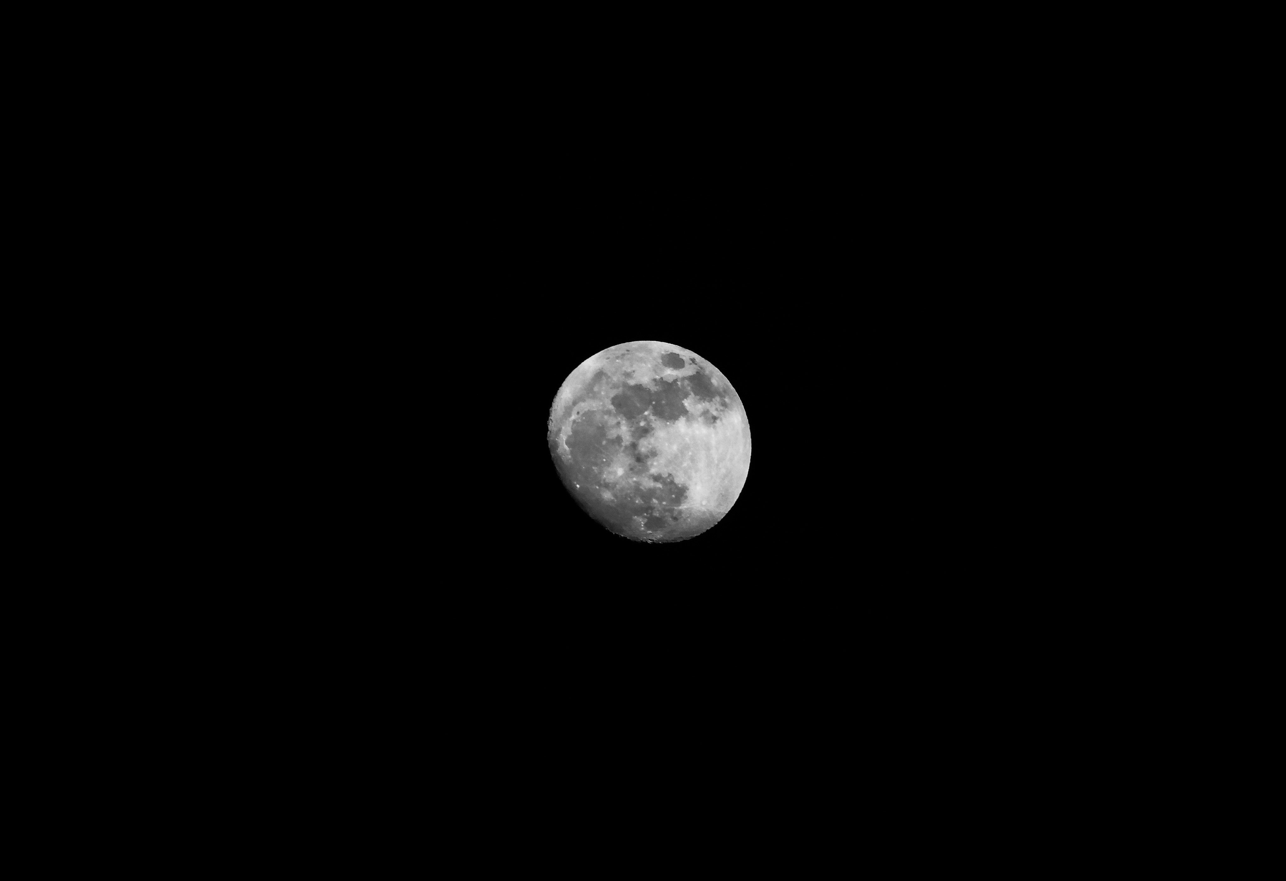Bright lunar disk against a deep black sky, isolated with minimal context and ample negative space.